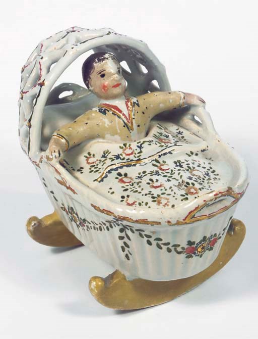 A Dutch Delft model of a baby in a cradle