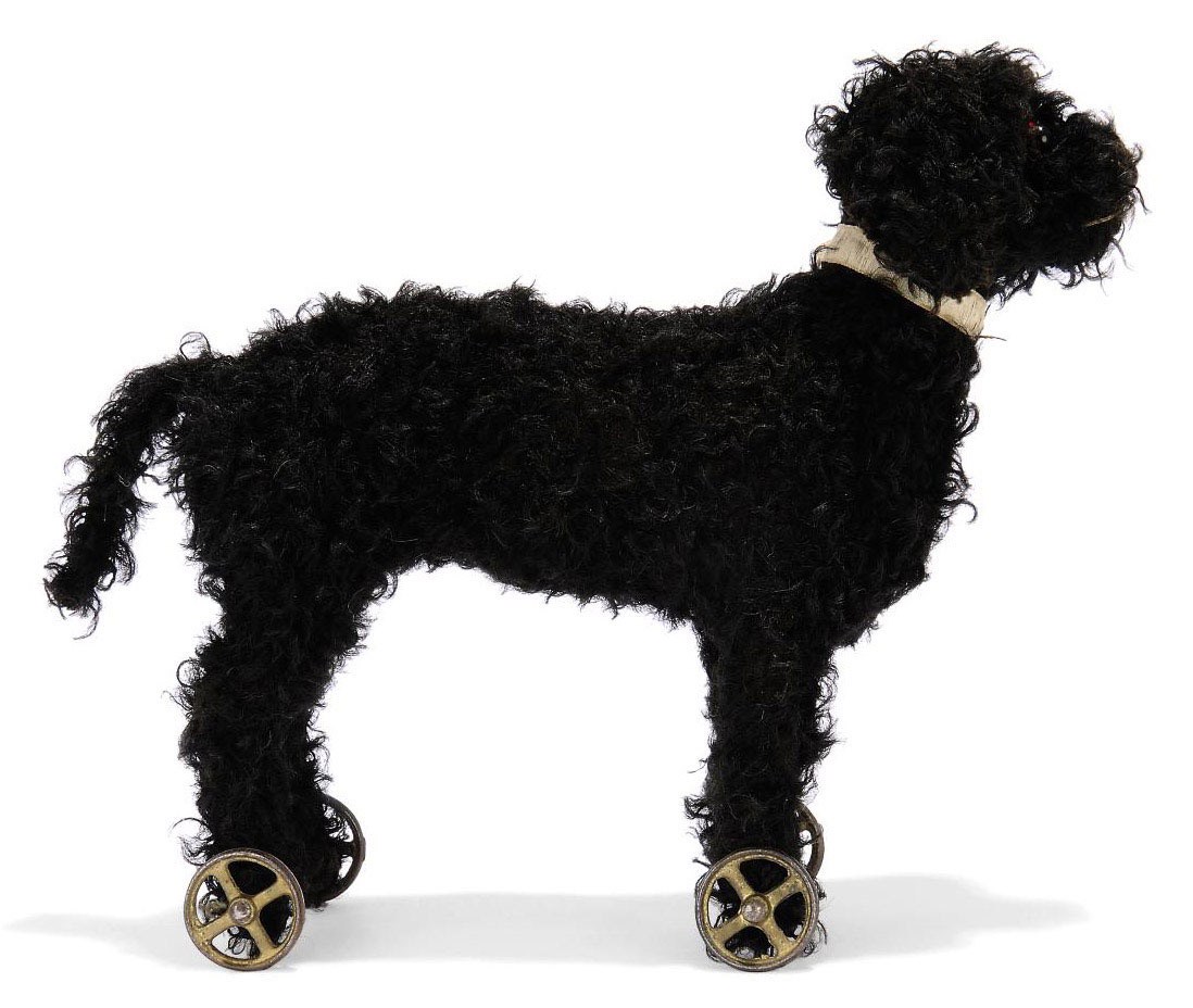 A STEIFF EARLY STANDING POODLE ON WHEELS, (22 or 1222), black curly ...