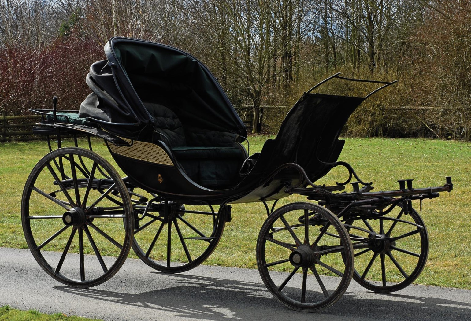 AN EARLY VICTORIAN BLACK-JAPANNED AND LIVERY-PAINTED HOODED PHAETON ...