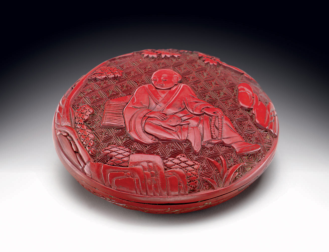 A CARVED RED LACQUER SHALLOW CIRCULAR BOX AND COVER