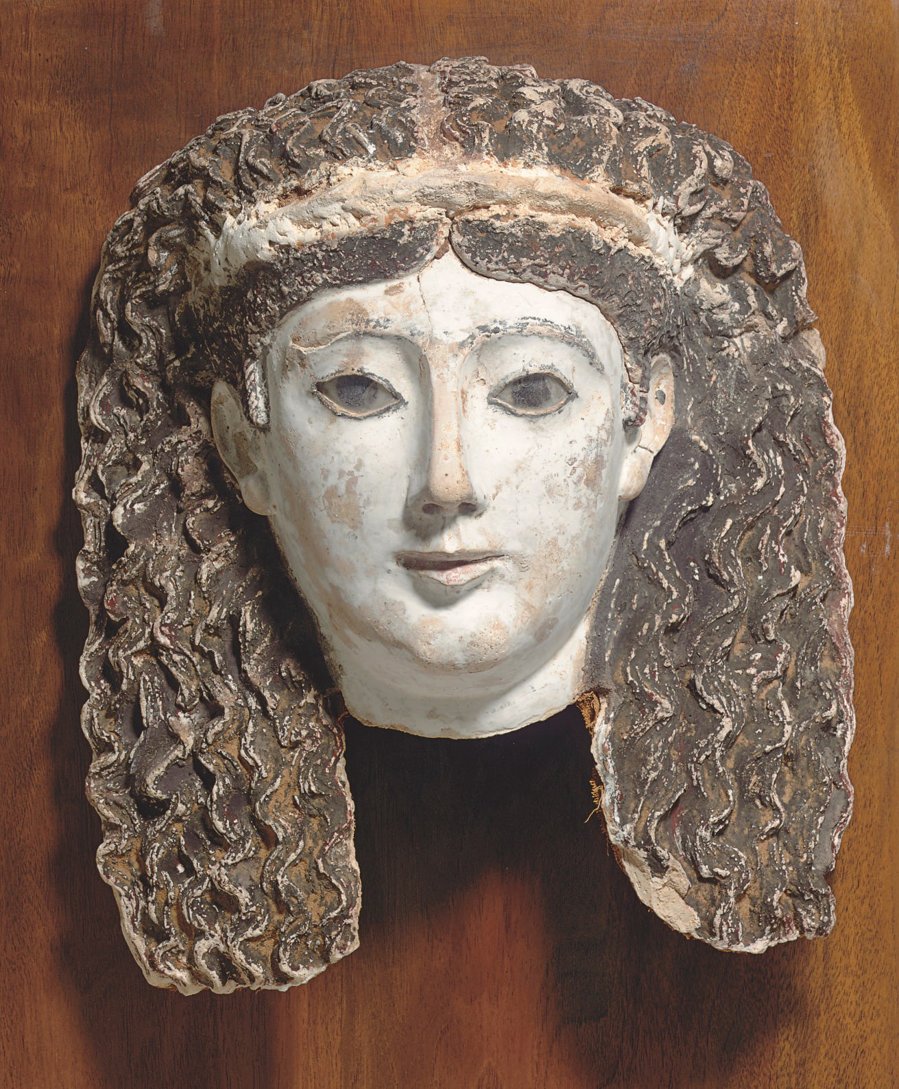 AN EGYPTIAN PAINTED PLASTER MUMMY MASK OF A WOMAN , ROMAN PERIOD, CIRCA ...