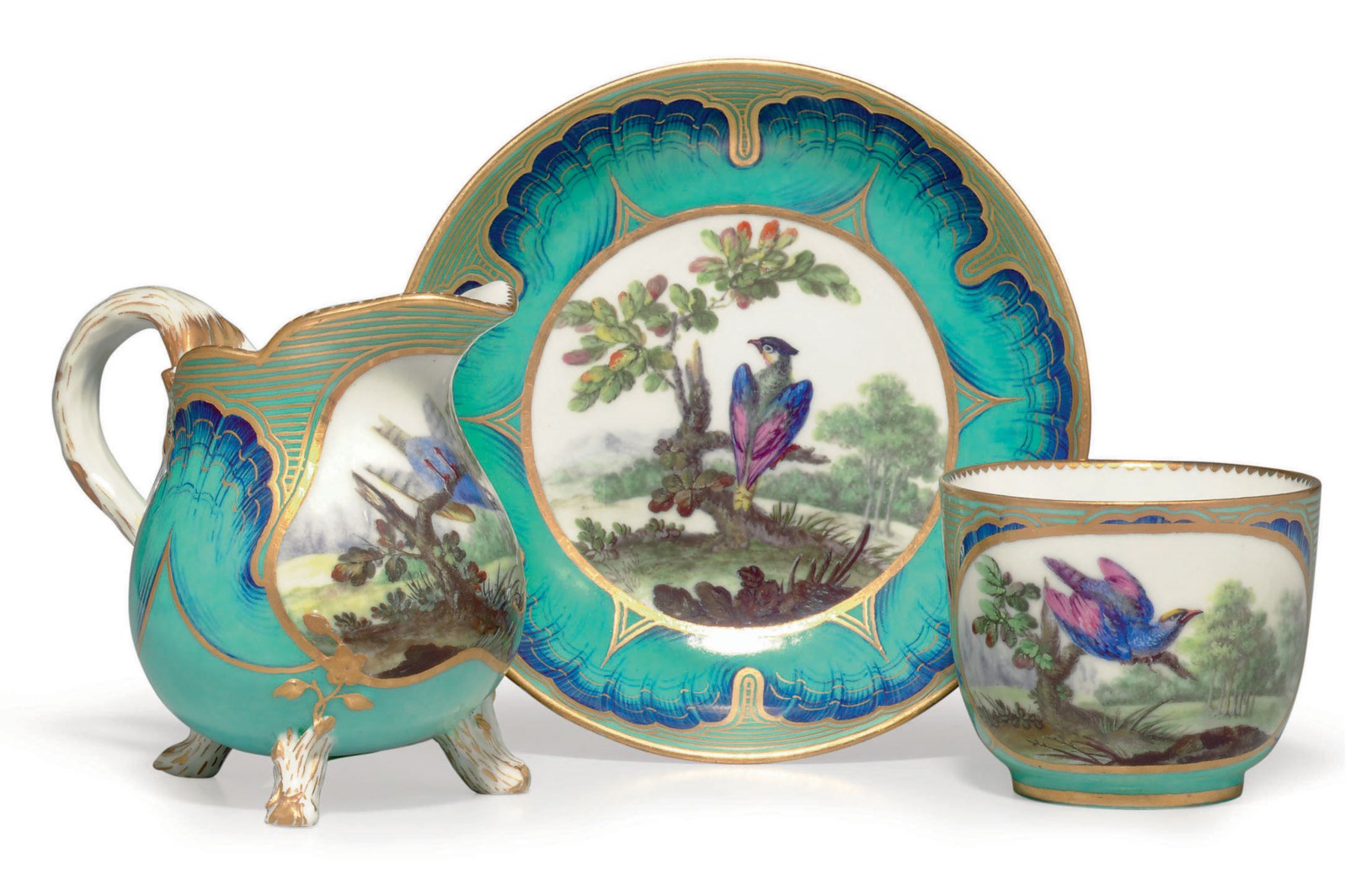 A SEVRES PORCELAIN PEACOCK-BLUE GROUND FOOTED CREAM-JUG, CUP AND SAUCER ...