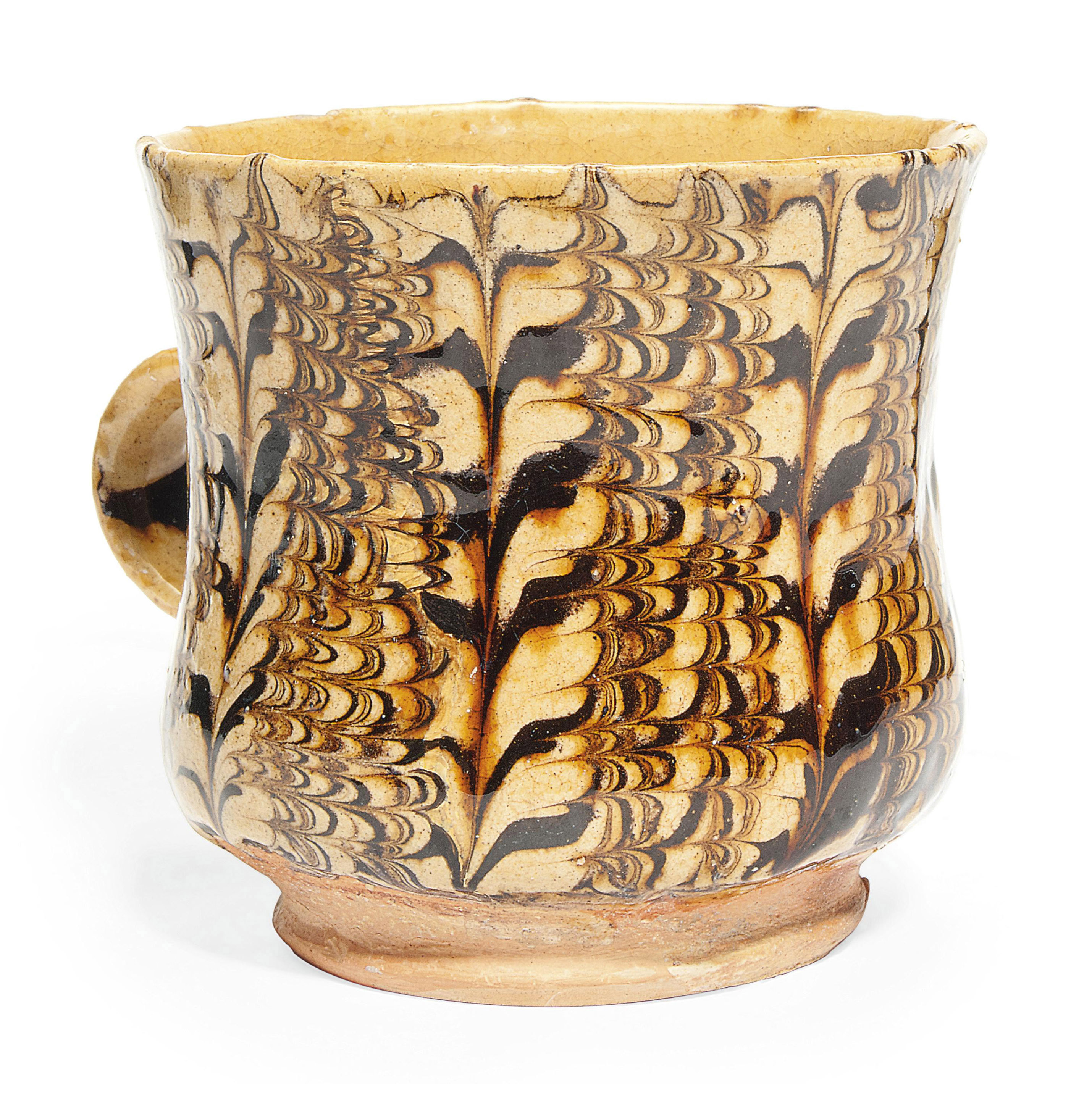 A STAFFORDSHIRE SLIPWARE SMALL BALUSTER MUG , CIRCA 1690-1710 | Christie's