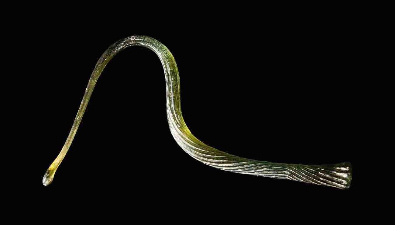 A ROMAN GREEN GLASS STRIGIL