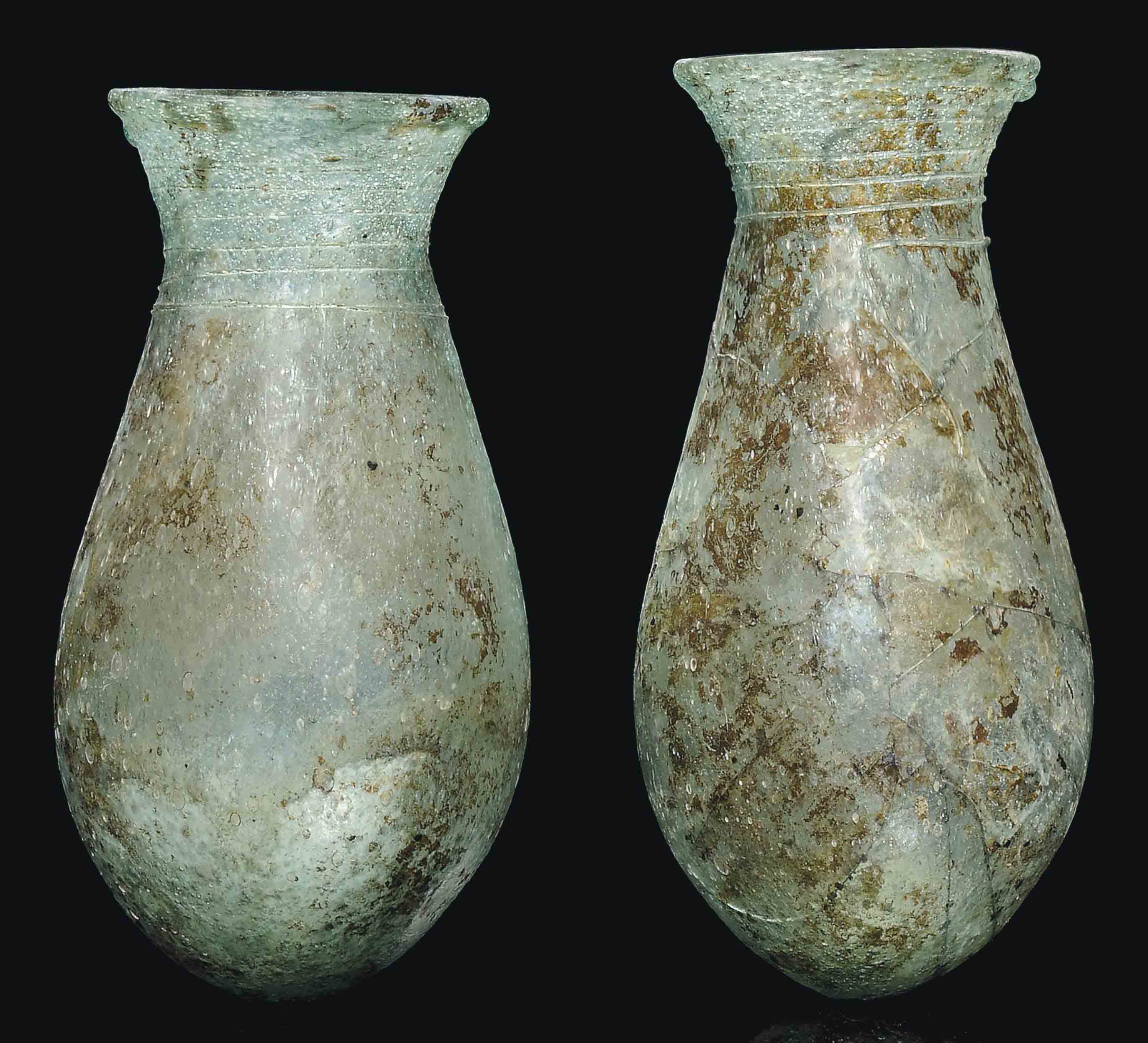 TWO ANGLO-SAXON GREENISH-BLUE GLASS POUCH BOTTLES