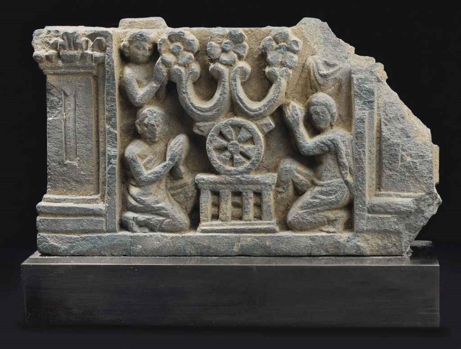 A gray schist relief of the Triratna Adored
