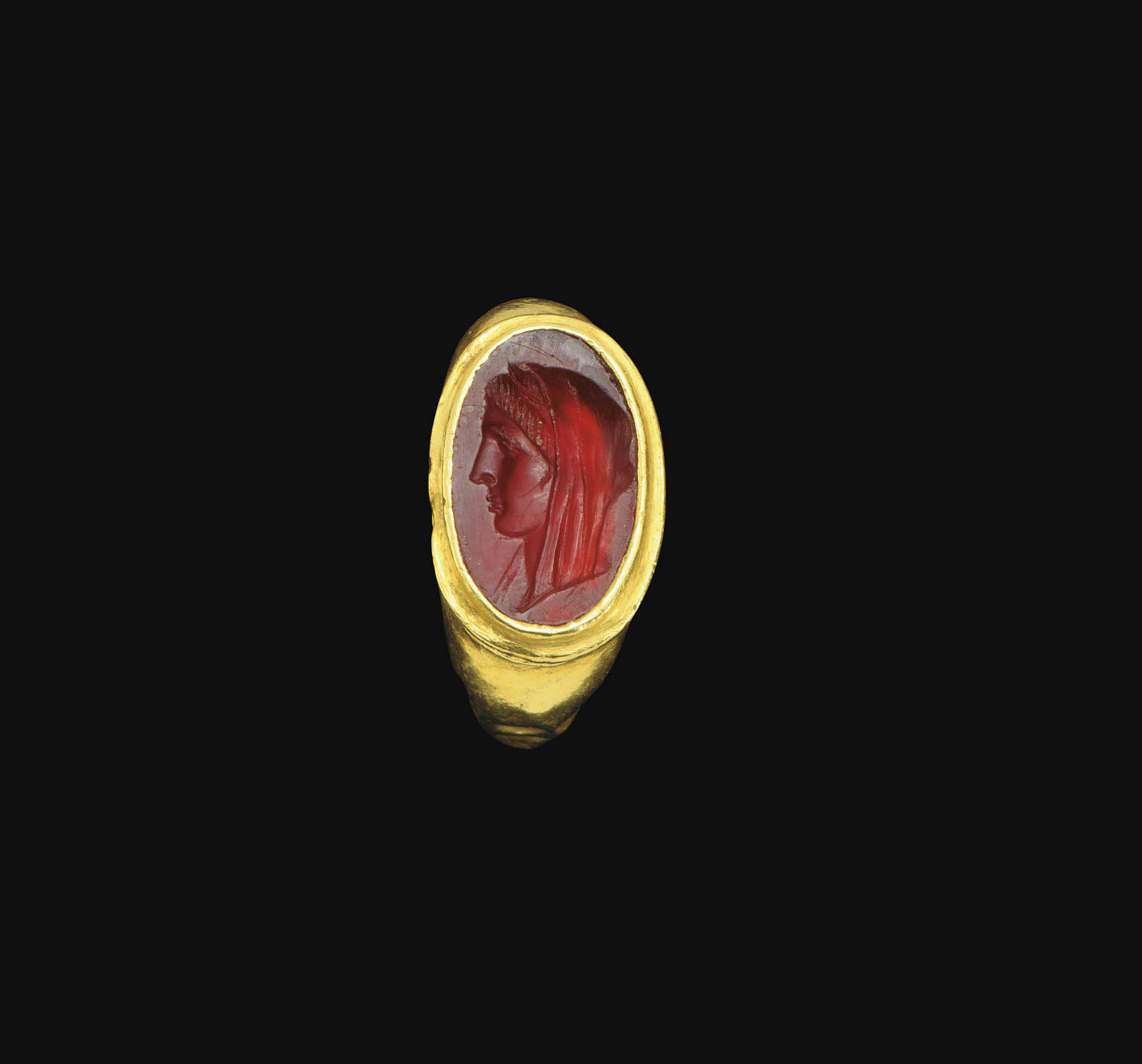 AN EGYPTIAN GOLD AND GARNET FINGER RING