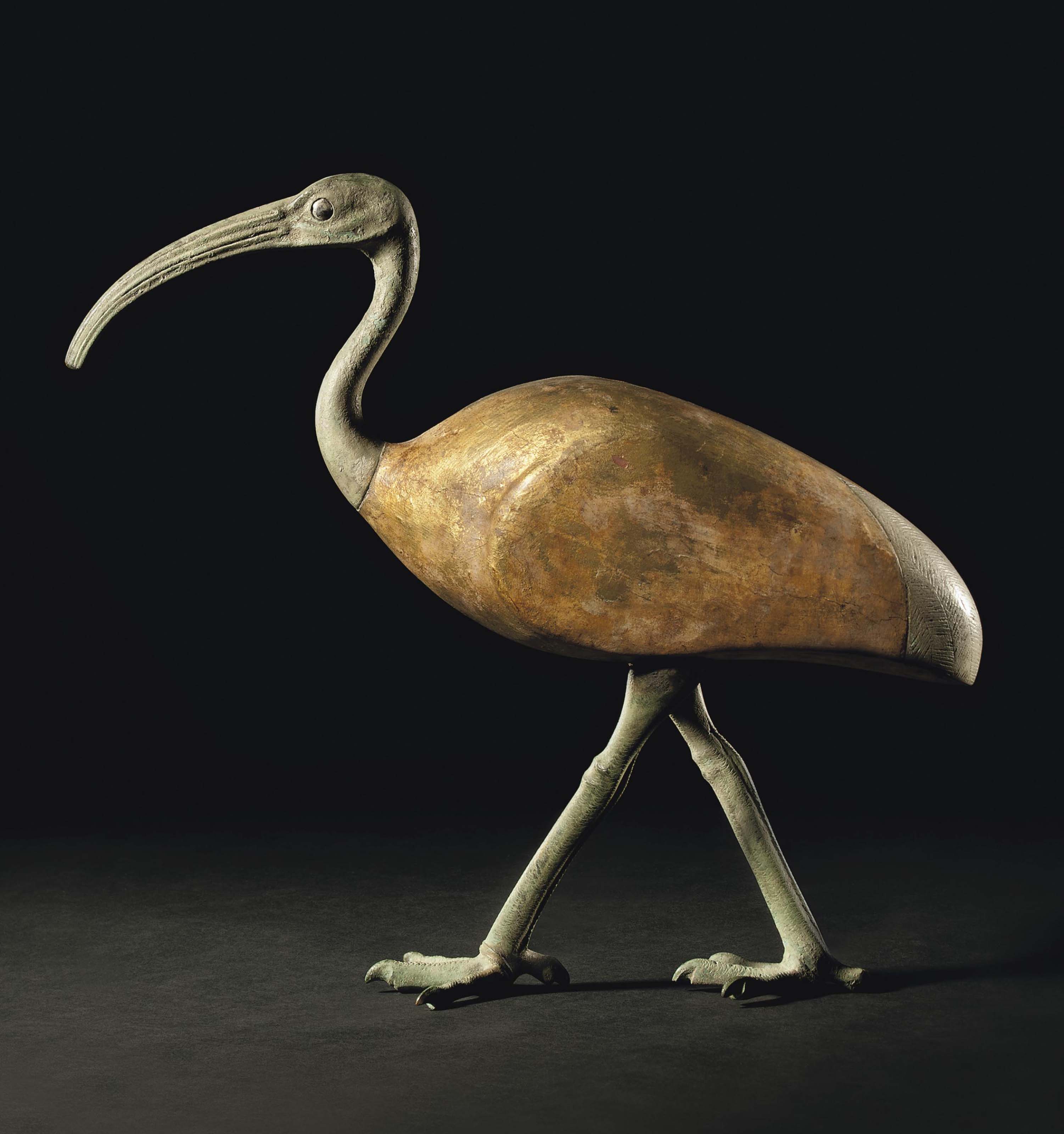 AN EGYPTIAN BRONZE AND GILT WOOD IBIS