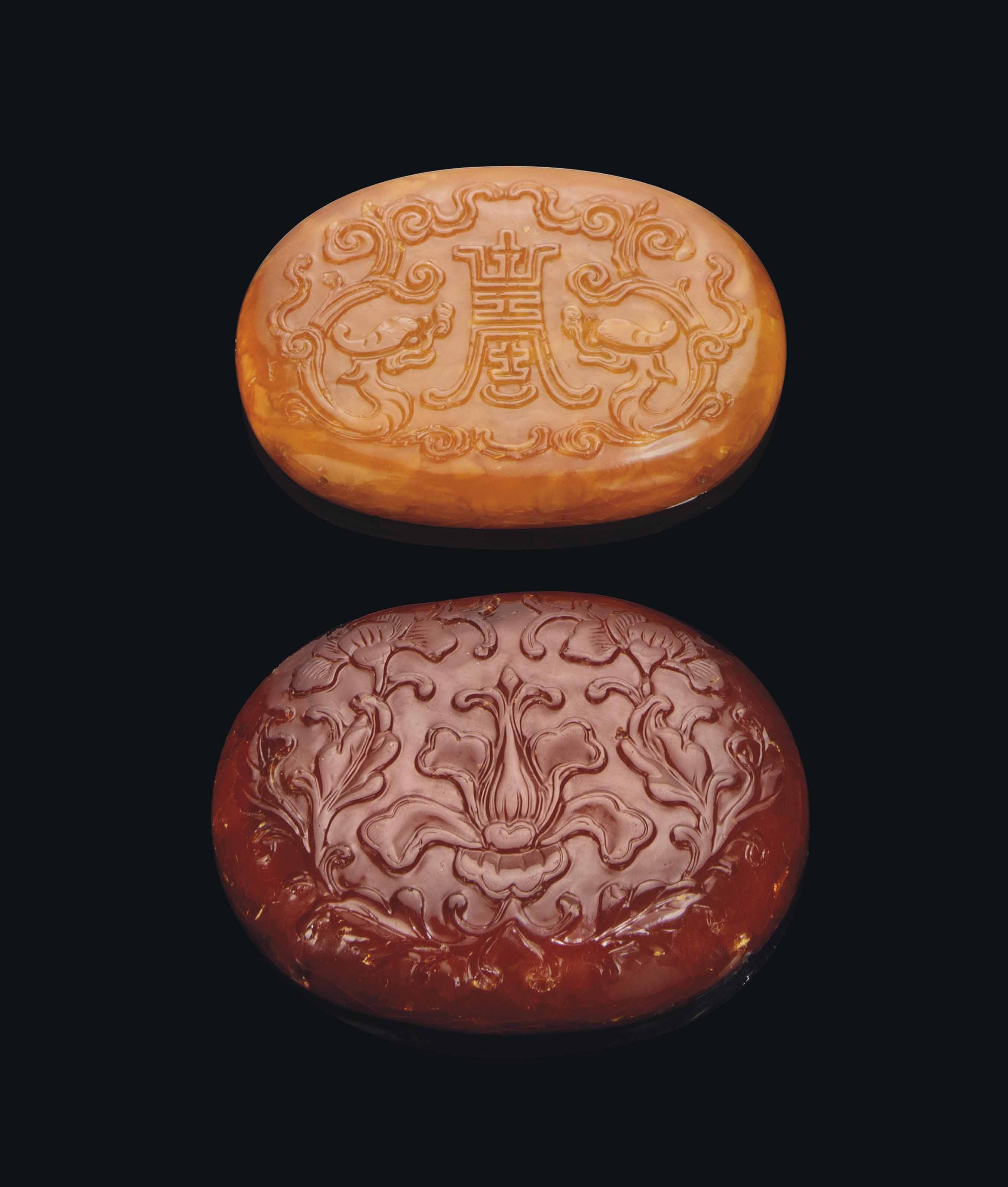 TWO CHINESE CARVED OVAL AMBER PLAQUES