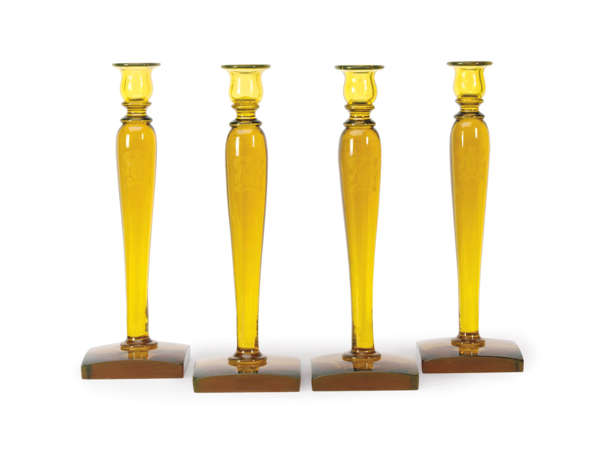 A SET OF FOUR LARGE AMBER GLASS CANDLESTICKS ENGRAVED WITH PSEUDO ...