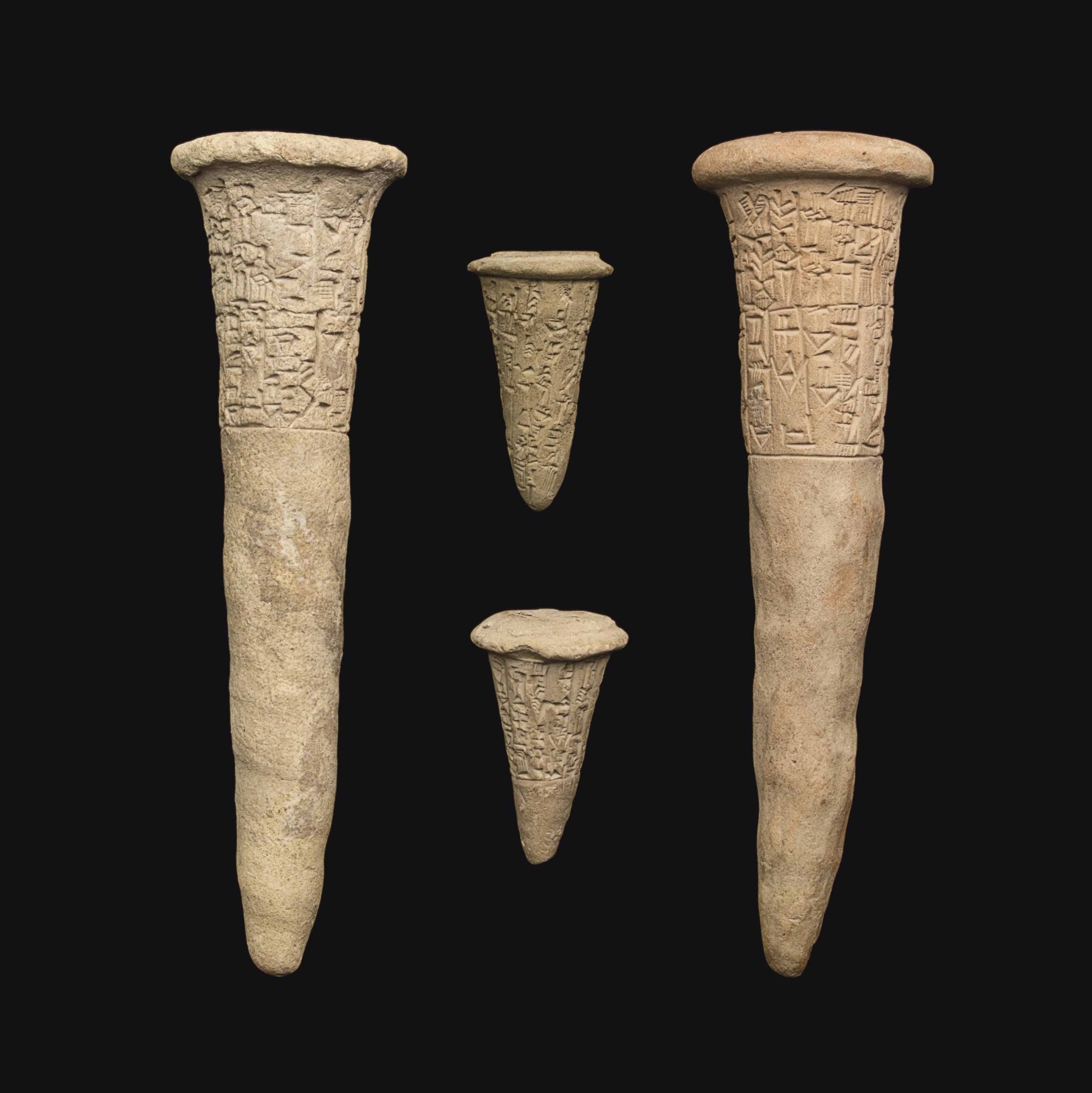 FOUR SUMERIAN TERRACOTTA CUNEIFORM CONES