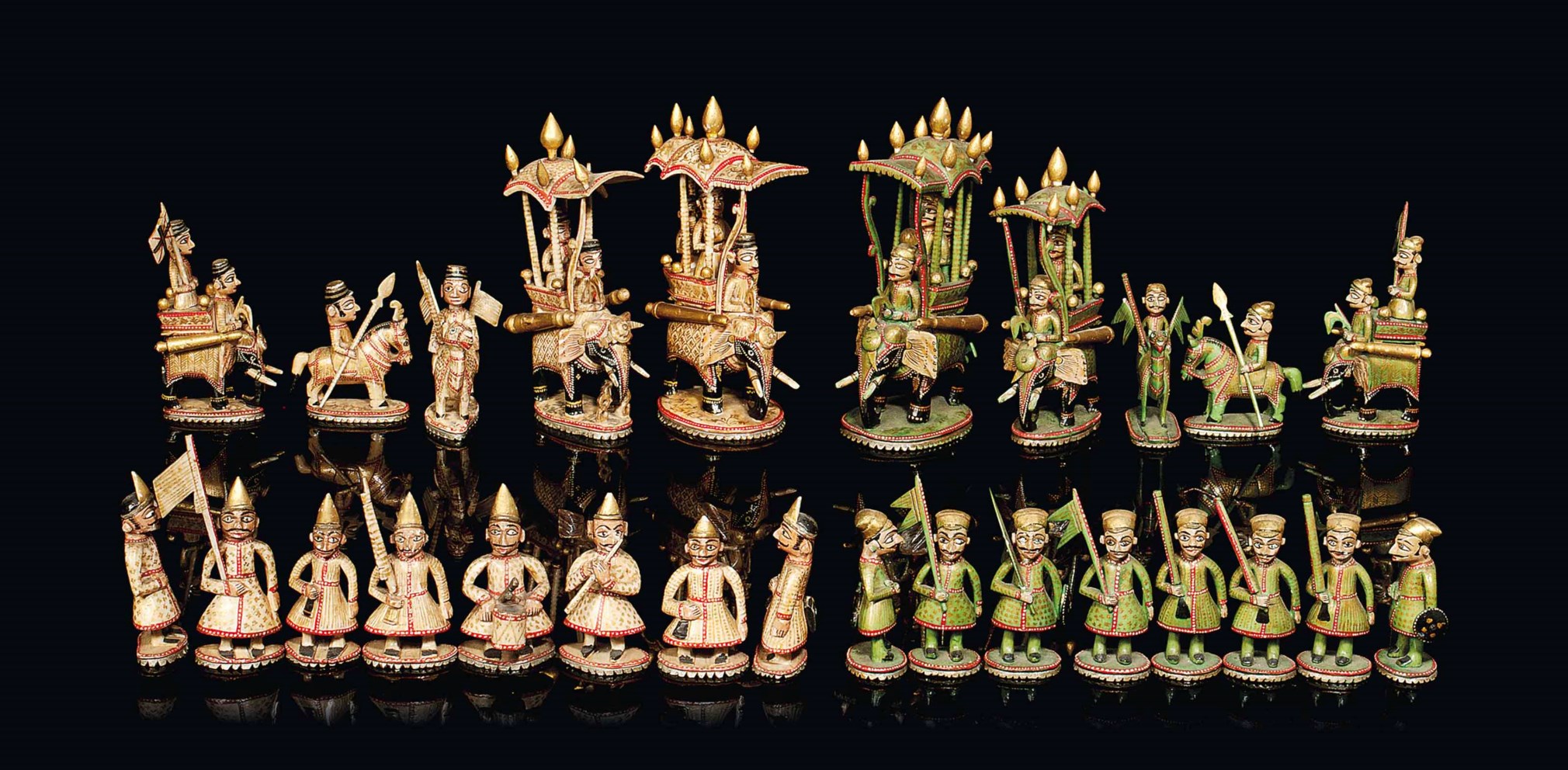 AN INDIAN GILT-HEIGHTENED POLYCHROME IVORY FIGURAL CHESS SET ...