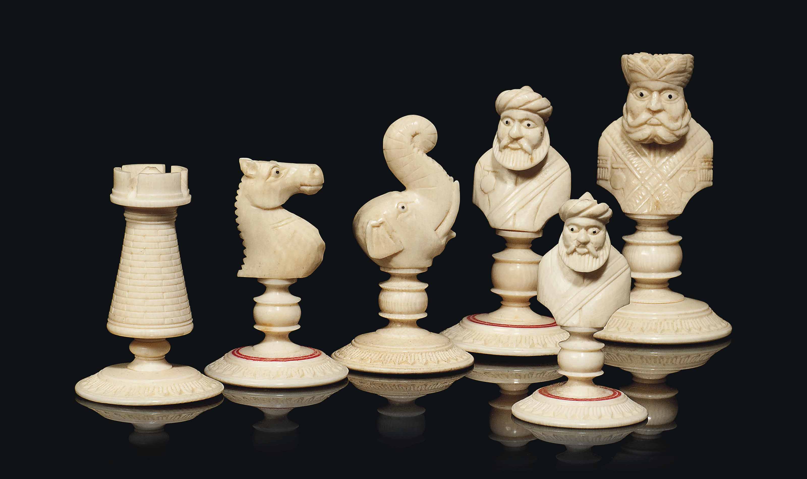 AN INDIAN GILT-HEIGHTENED POLYCHROME IVORY FIGURAL CHESS SET ...