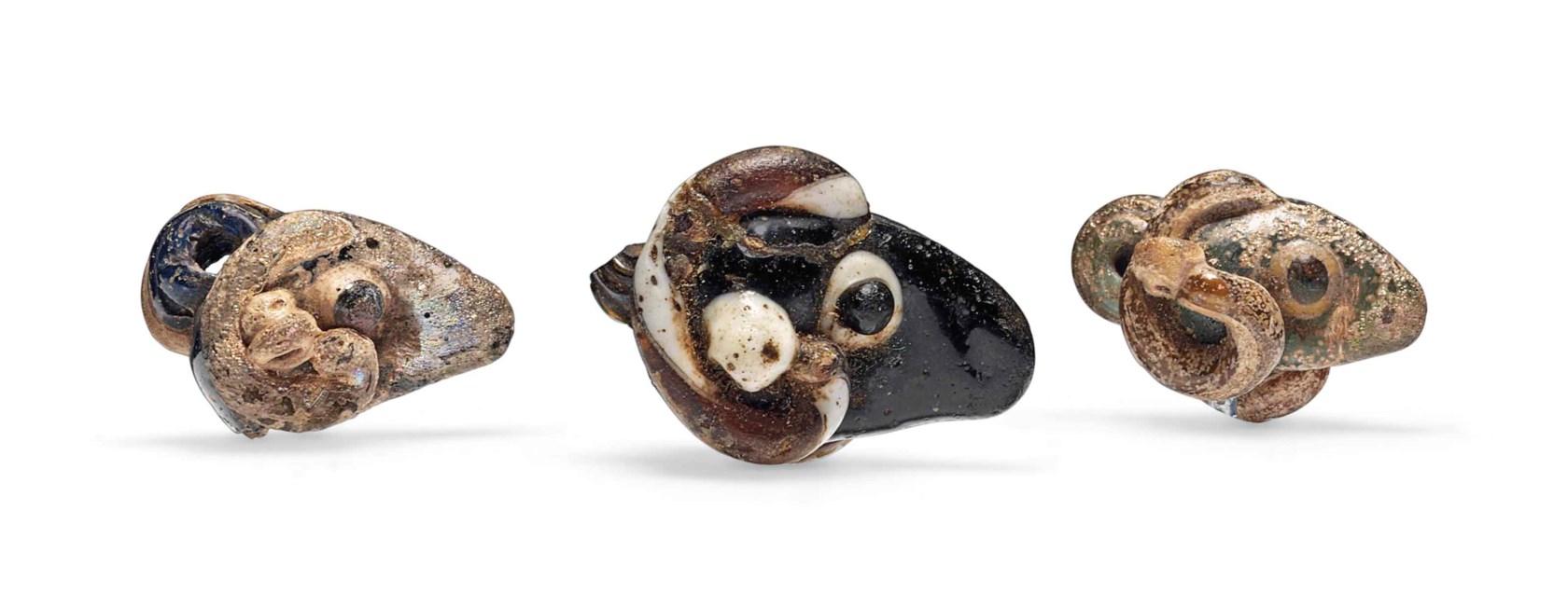 THREE CARTHAGINIAN GLASS RAM'S HEAD PENDANTS , CIRCA 7TH-5TH CENTURY B ...
