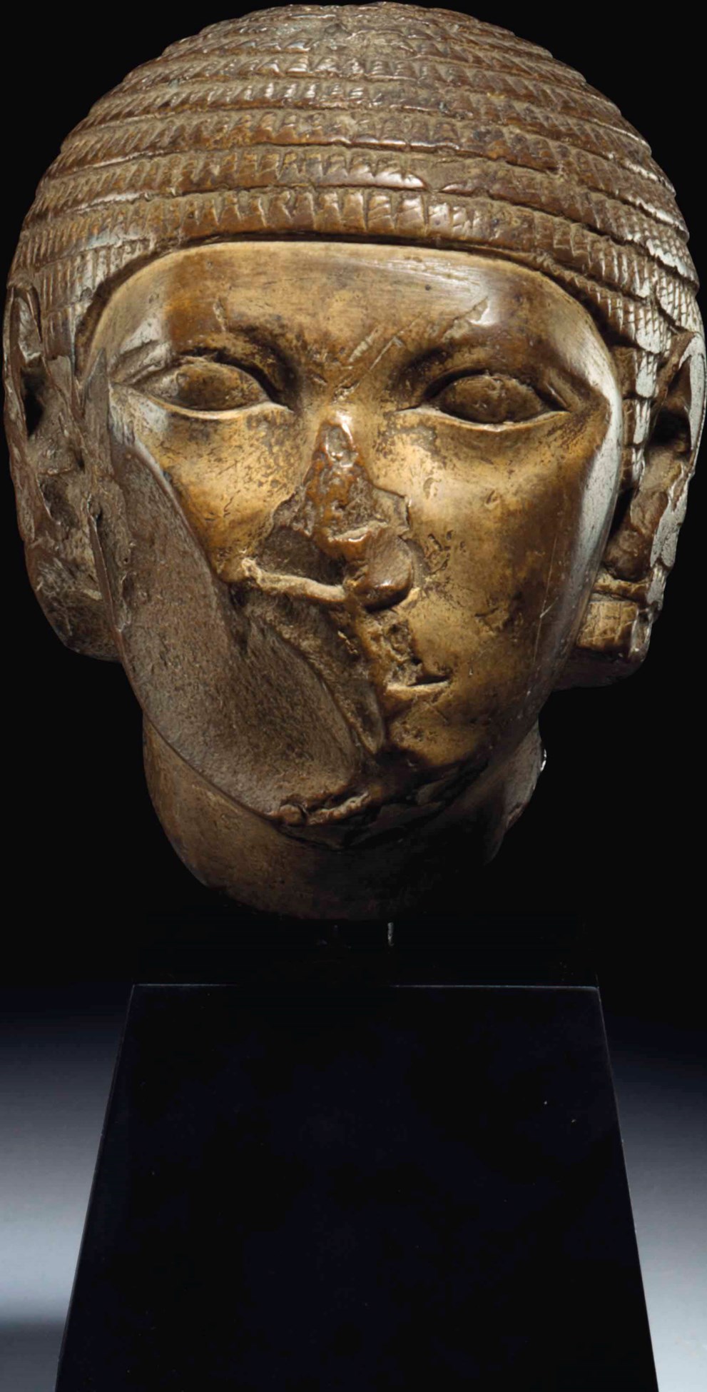 AN EGYPTIAN INDURATED LIMESTONE HEAD OF A MAN