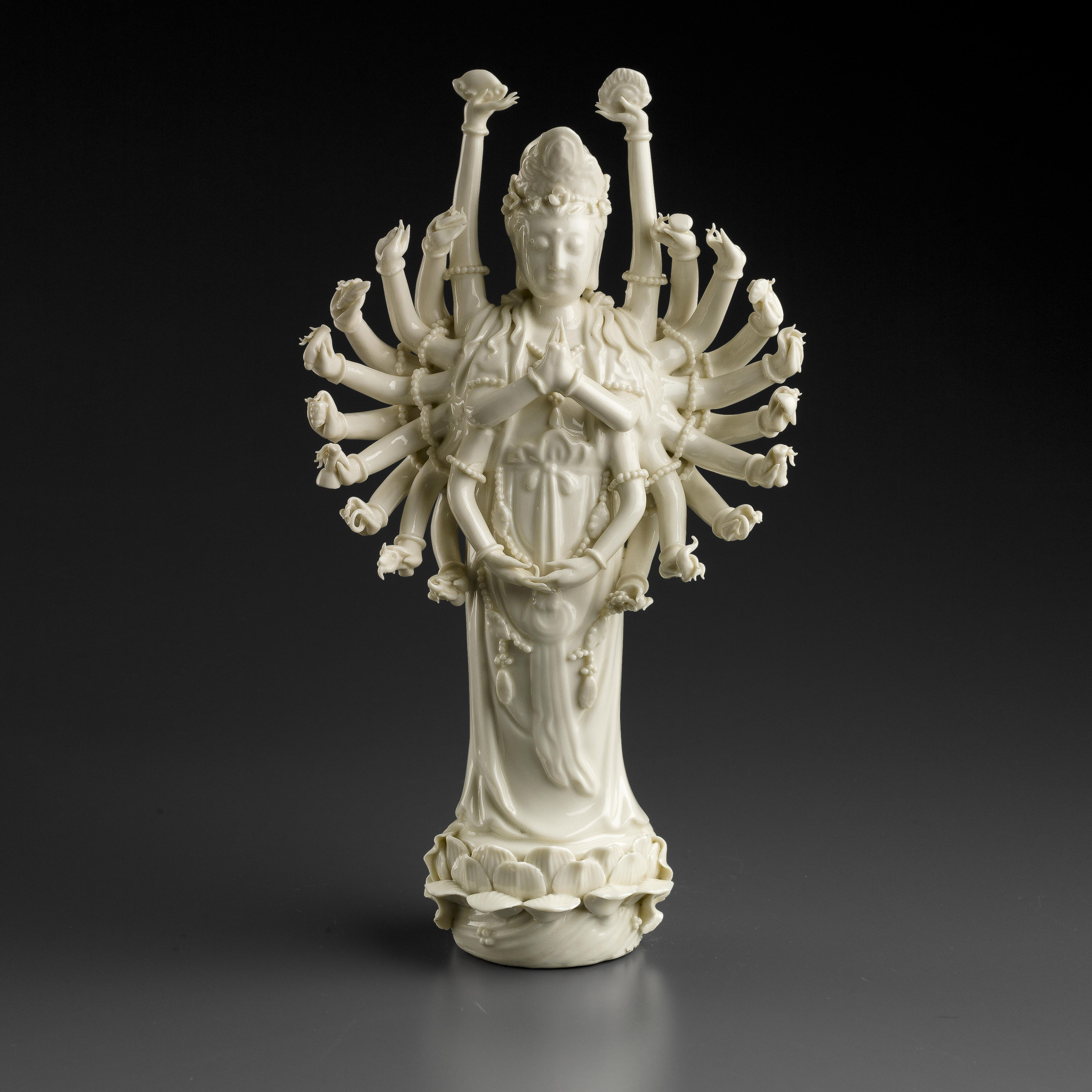 A GLAZED WHITE PORCELAIN MULTI-ARMED FIGURE OF DOUMU, 20TH CENTURY ...