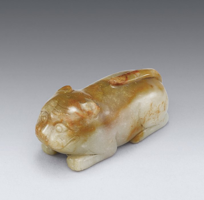 A CREAM AND RUSSET JADE CARVING OF A TIGER