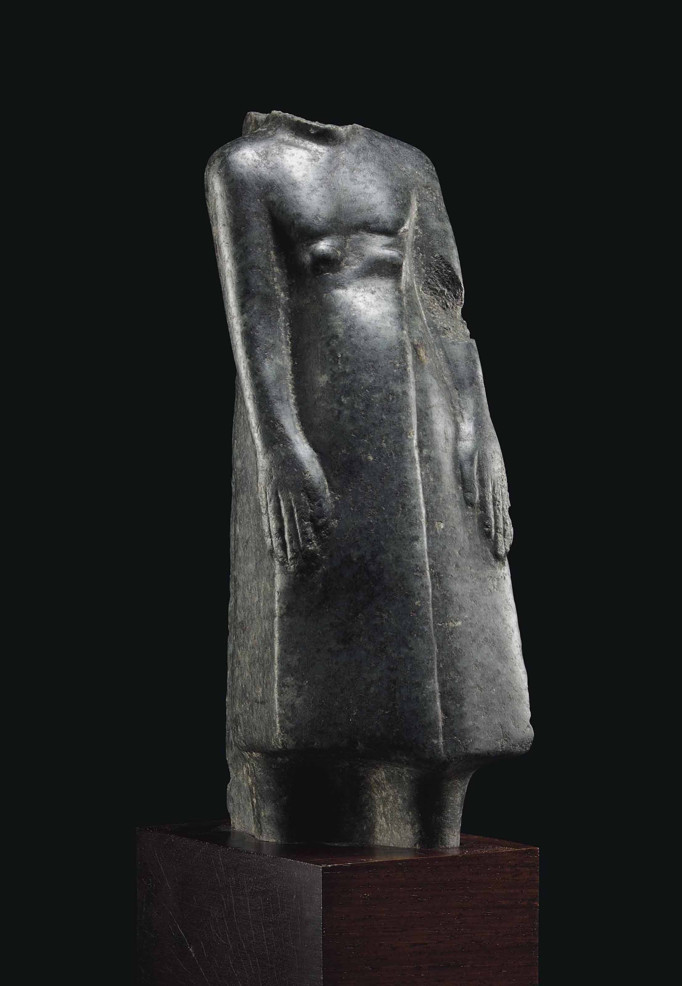 AN EGYPTIAN SERPENTINITE FIGURE OF AN OFFICIAL