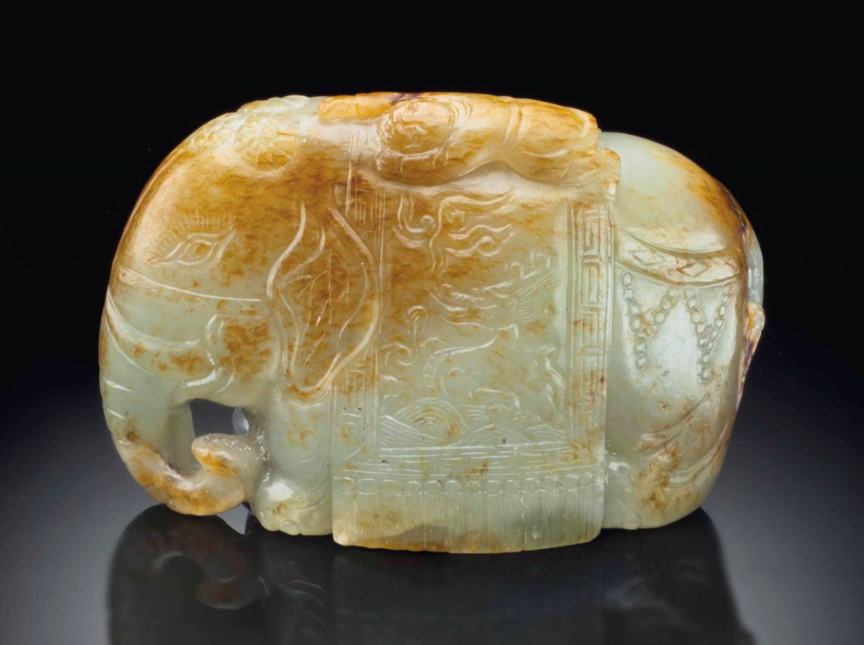 A SMALL PALE GREYISH-GREEN AND RUSSET JADE FIGURE OF AN ELEPHANT, LATE ...