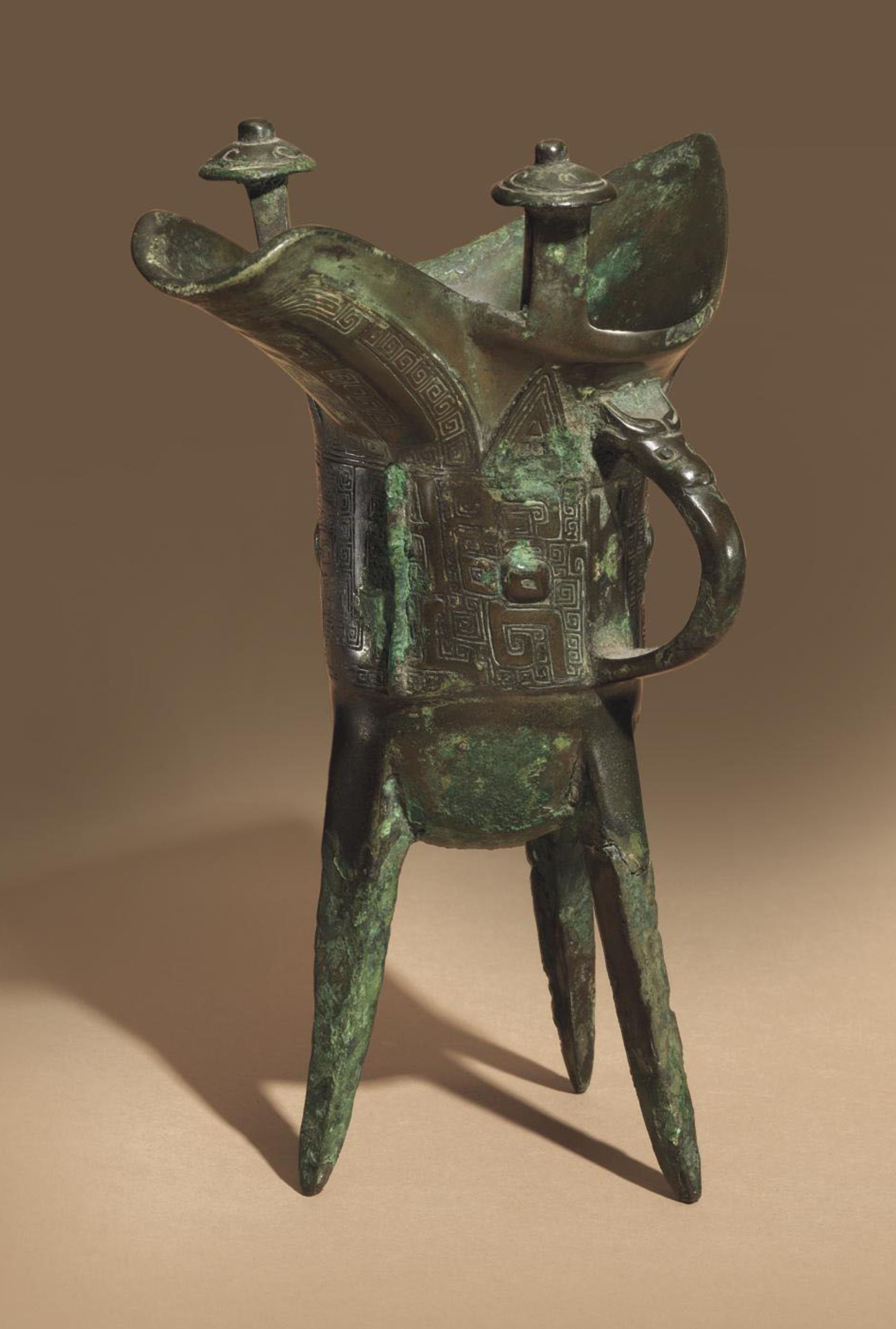 A BRONZE RITUAL TRIPOD WINE VESSEL, JUE