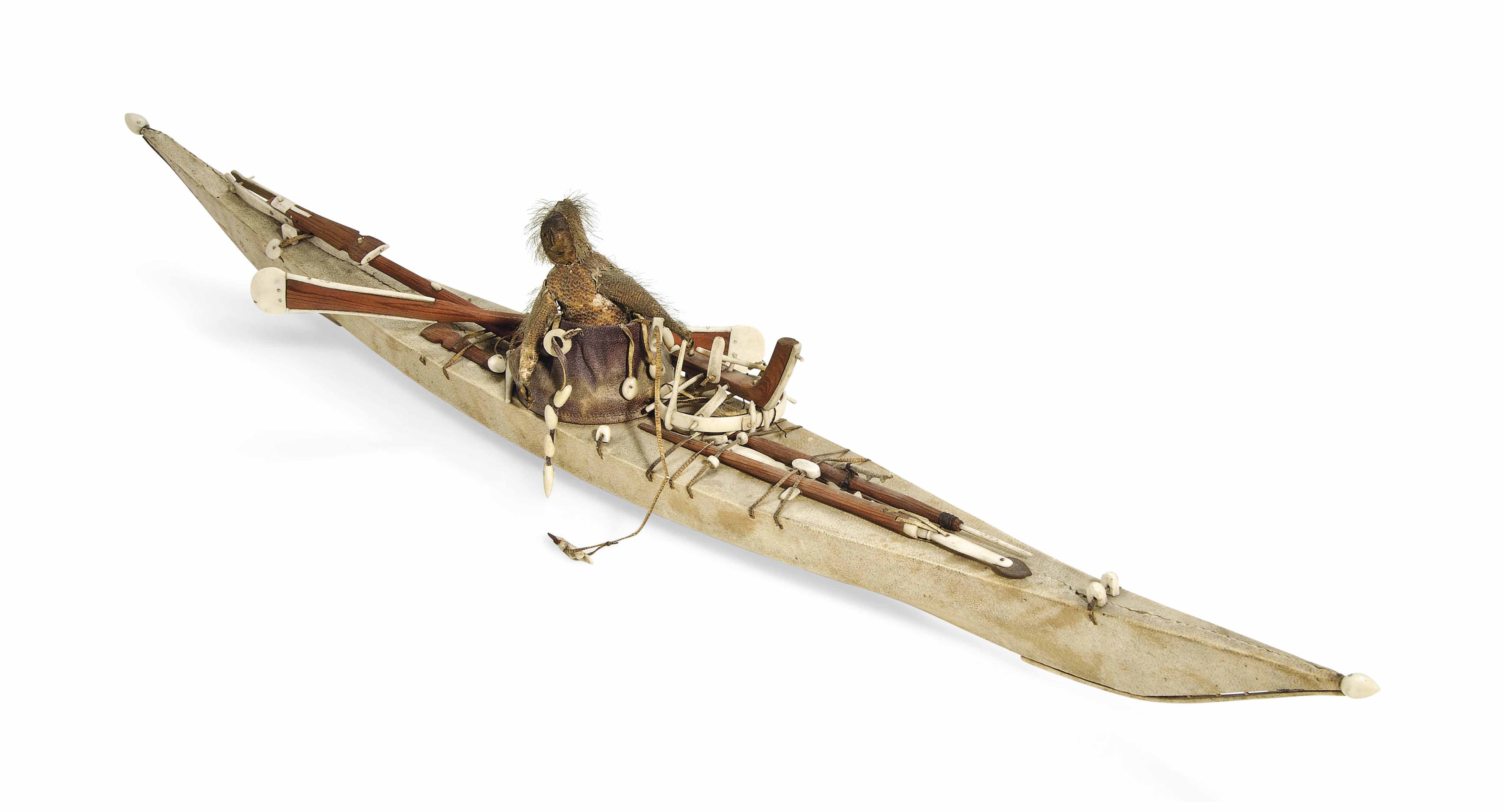 AN INUIT SEAL SKIN COVERED AND BONE MOUNTED WOOD MODEL OF A KAYAK AND ...