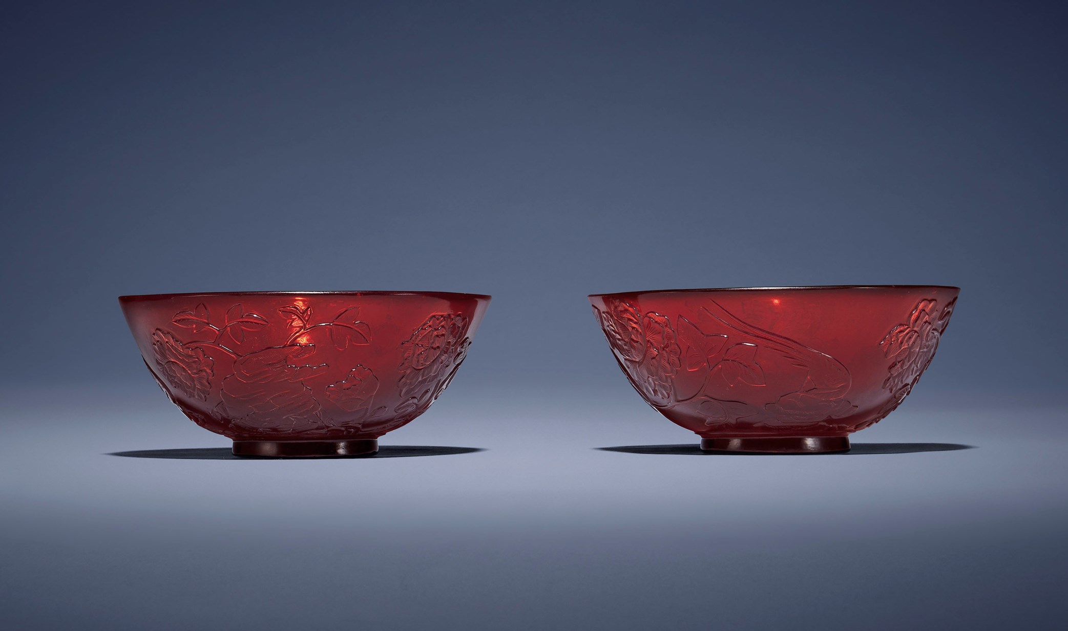 A RARE PAIR OF CARVED TRANSPARENT RUBY RED GLASS BOWLS, YONGZHENG ...