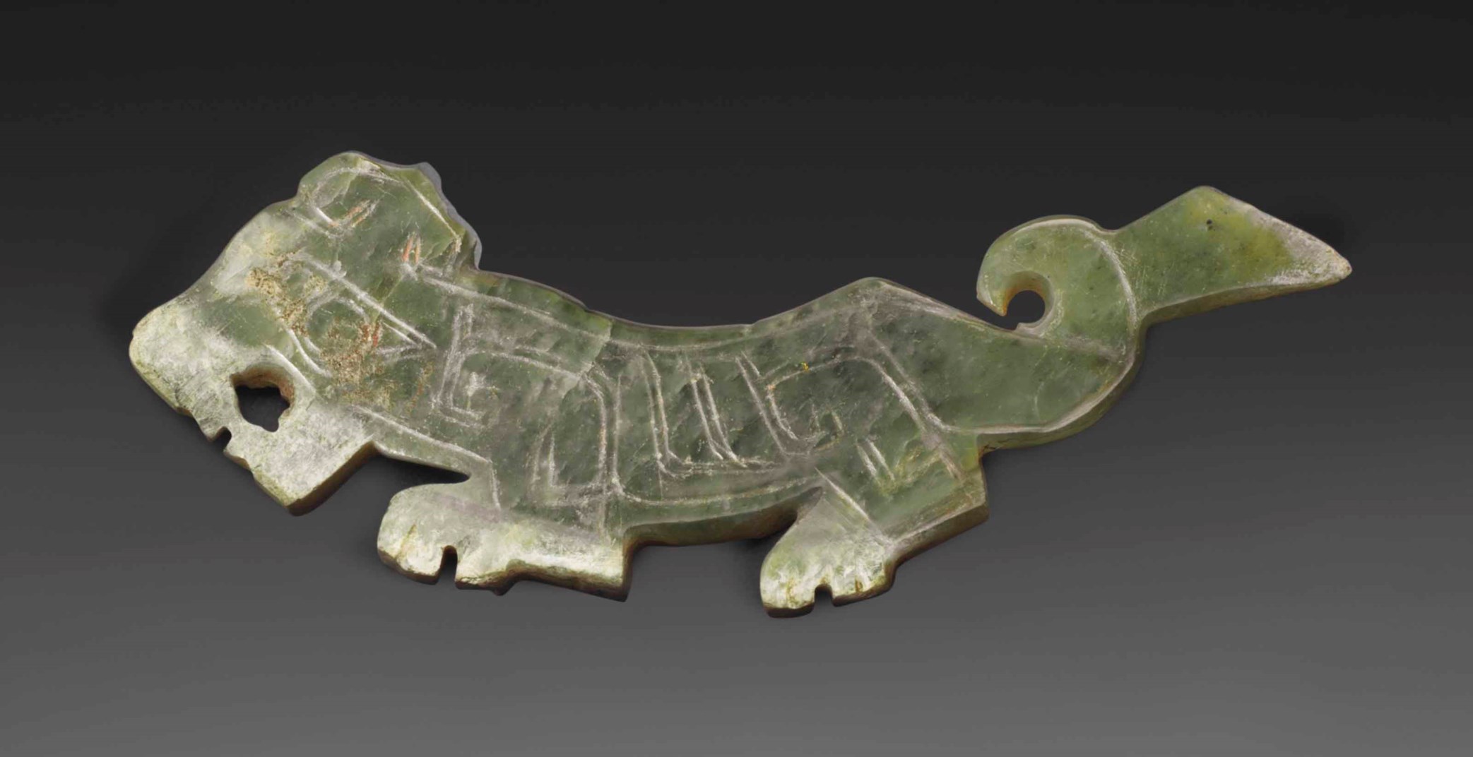 A RARE GREY-GREEN JADE TIGER-FORM FINIAL/INSIGNIA, LATE SHANG DYNASTY ...
