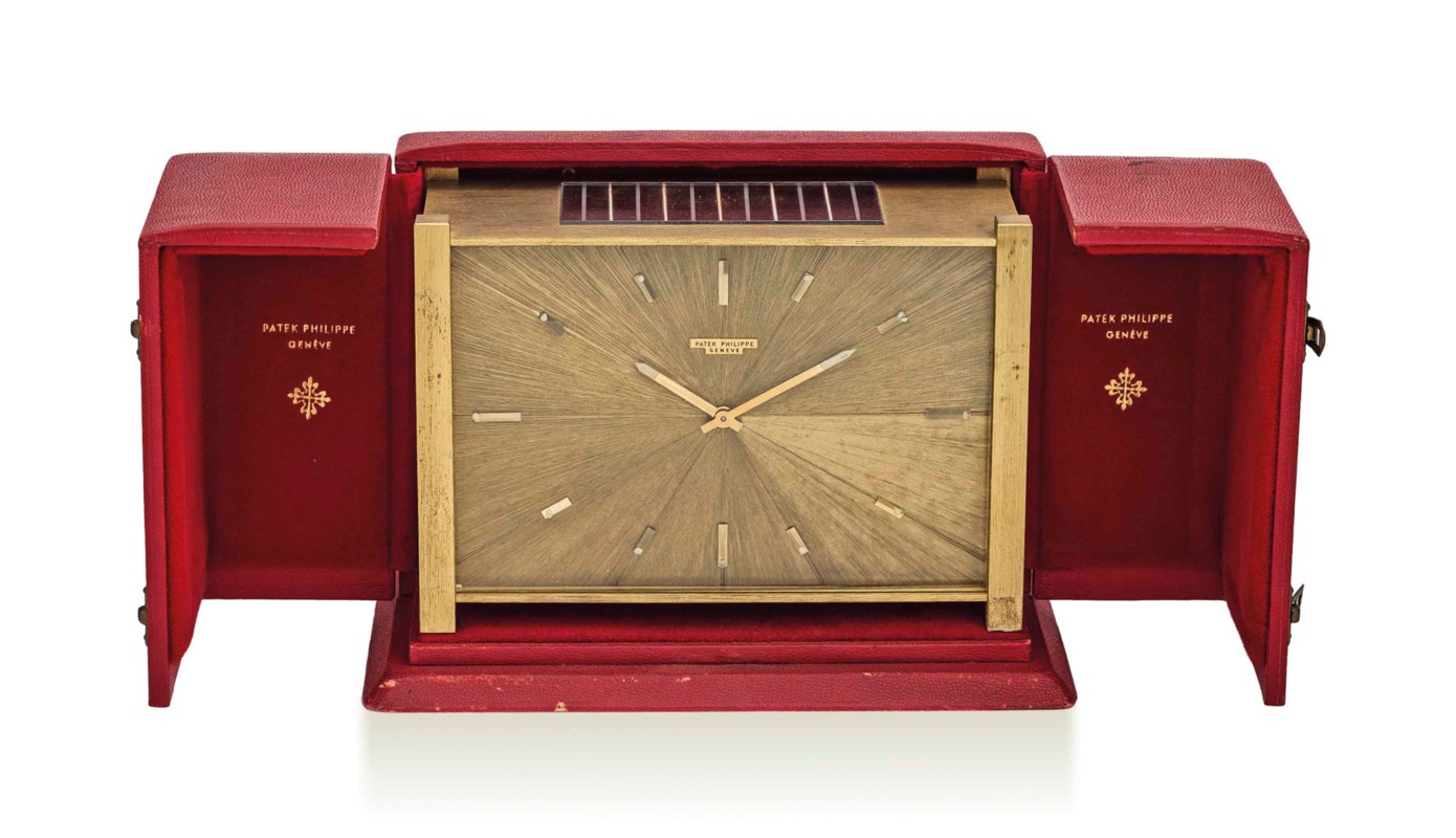 PATEK PHILIPPE. A FINE GILT BRASS RECTANGULAR SOLAR-POWERED DESK CLOCK ...