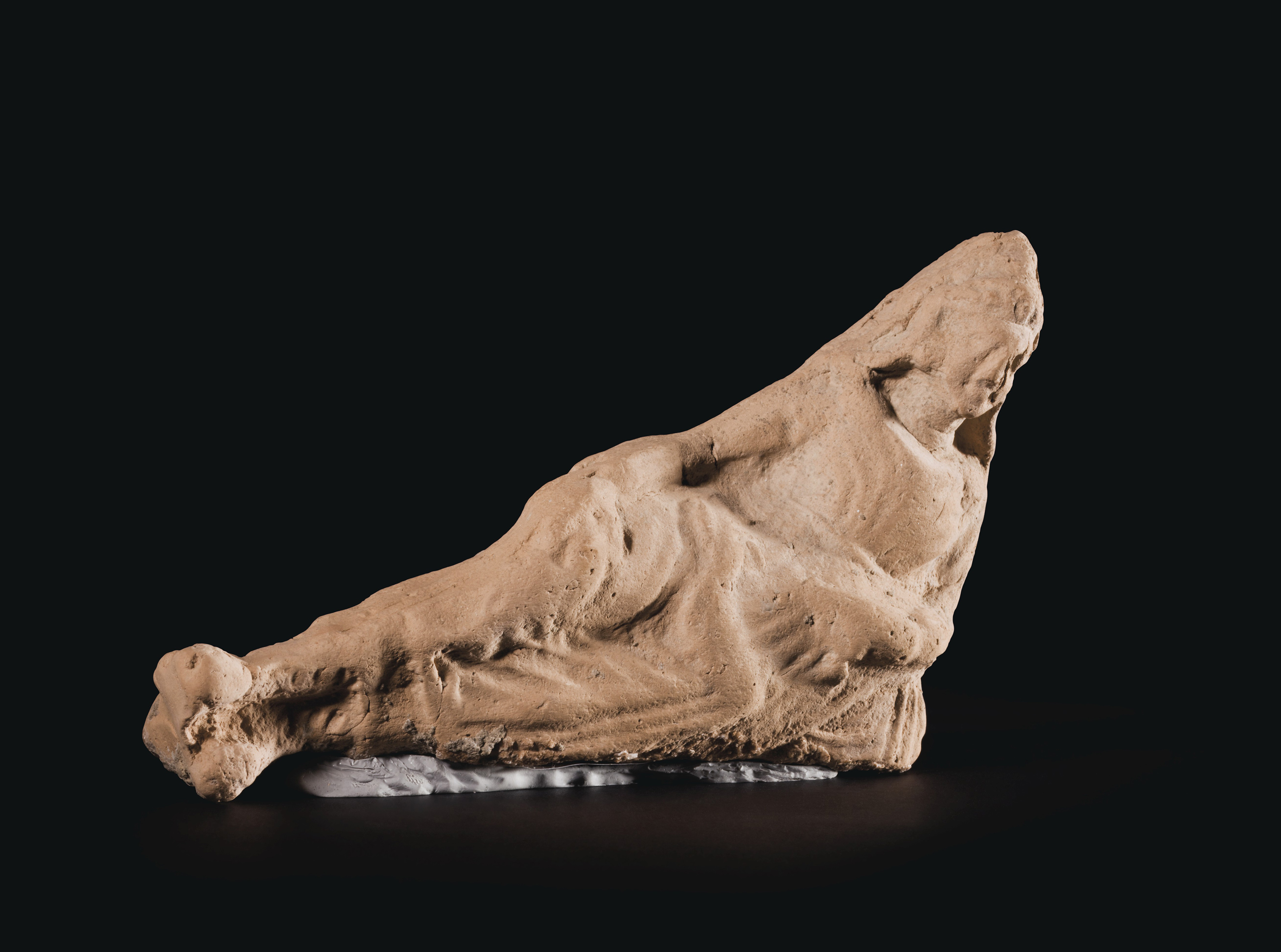 A GREEK TERRACOTTA RECLINING BANQUETER, HELLENISTIC PERIOD, CIRCA 4TH ...