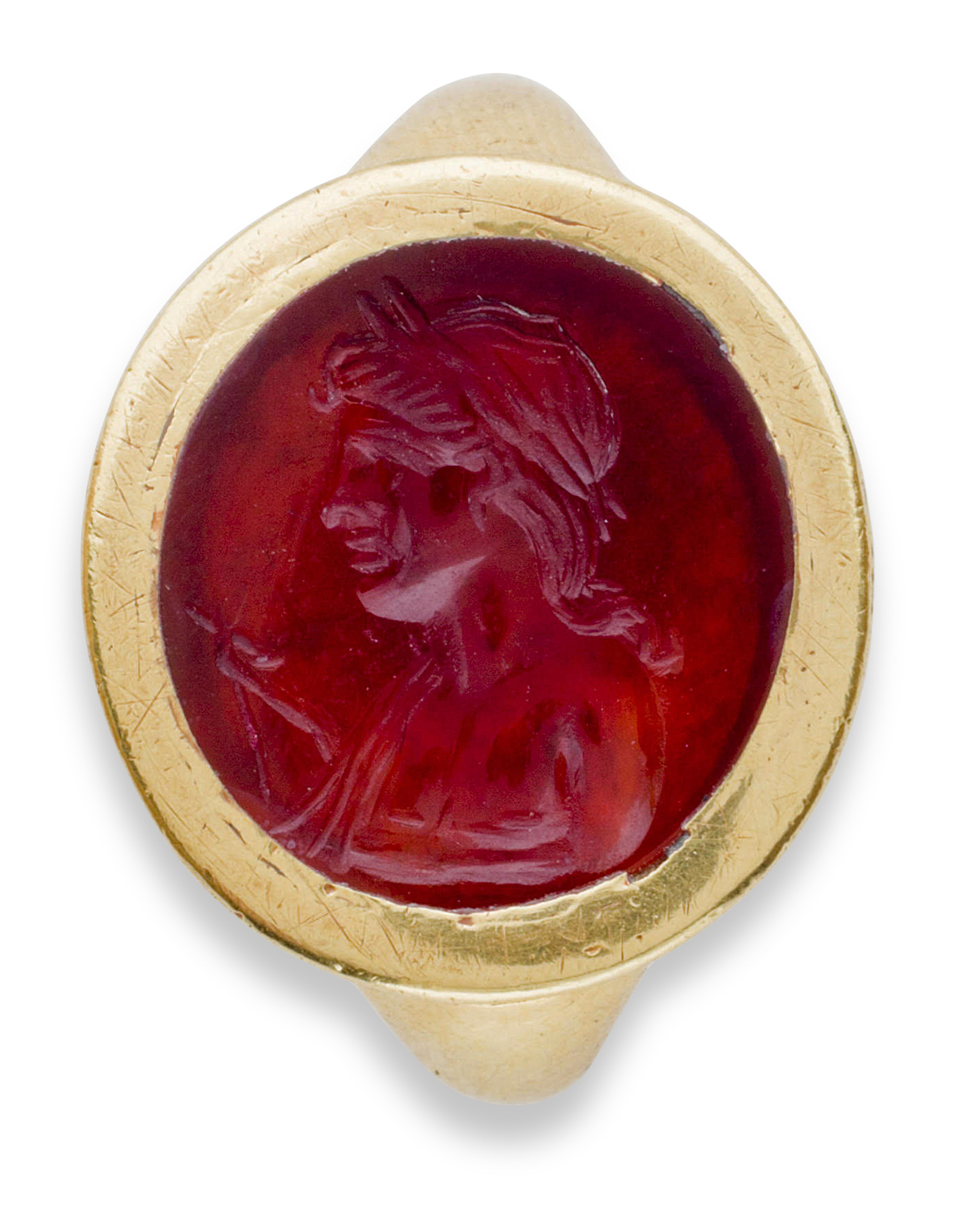 A ROMAN GOLD AND CARNELIAN FINGER RING WITH A BUST OF APOLLO, CIRCA 1ST ...