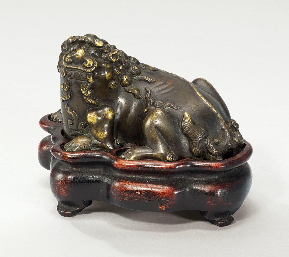 A BRONZE FIGURE OF A RECUMBENT LION, MING DYNASTY; CAST XUANDE SIX ...