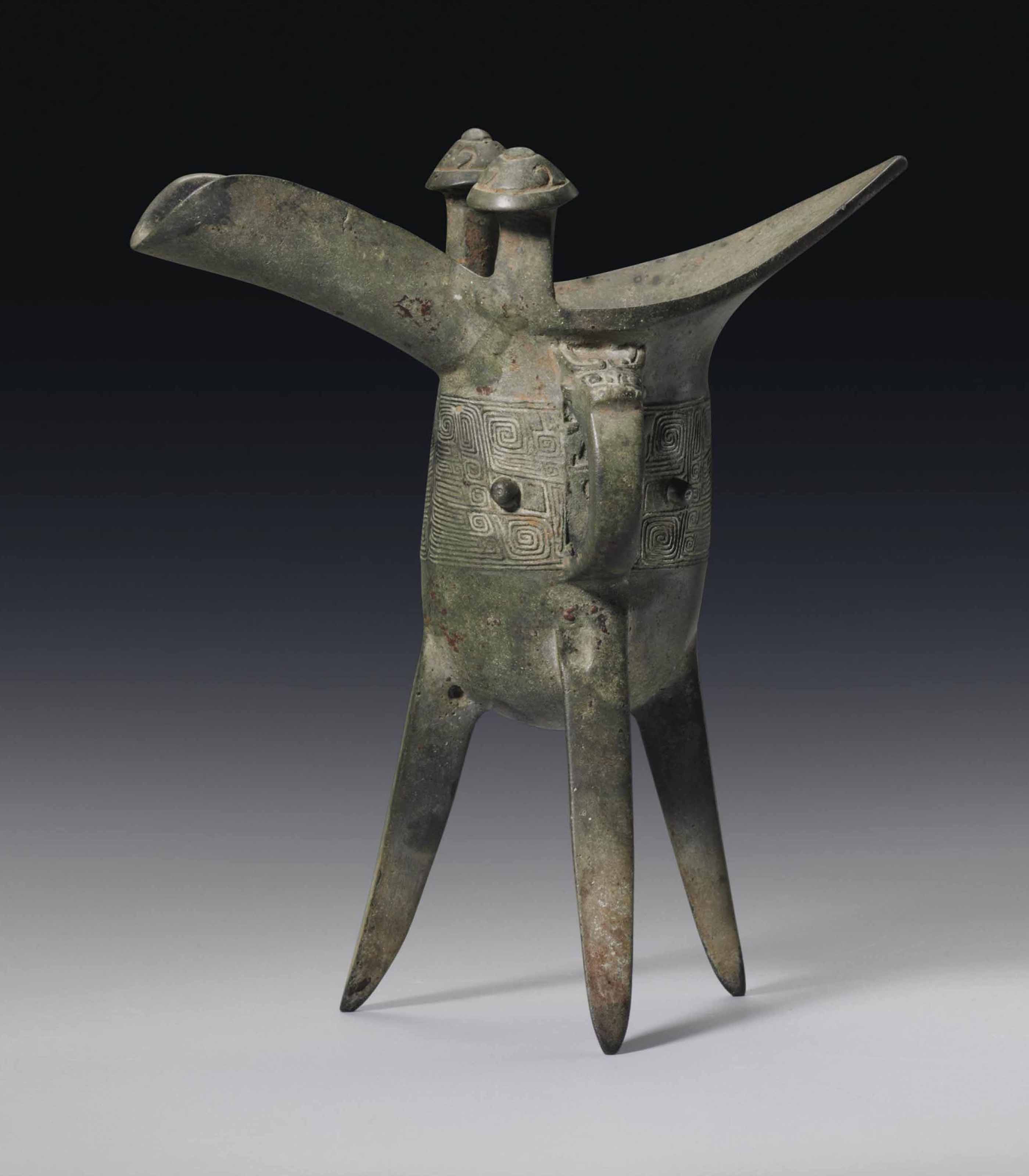 A BRONZE RITUAL TRIPOD WINE VESSEL, JUE