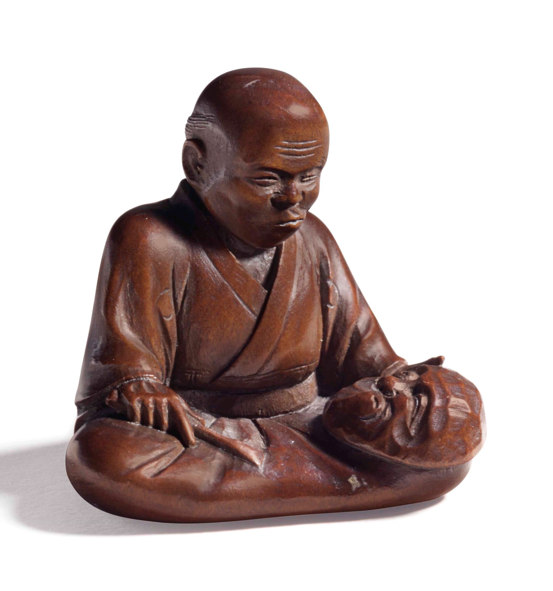 A WOOD NETSUKE OF A MASK CARVER, MEIJI PERIOD (DATED 1908), SIGNED JOSO ...