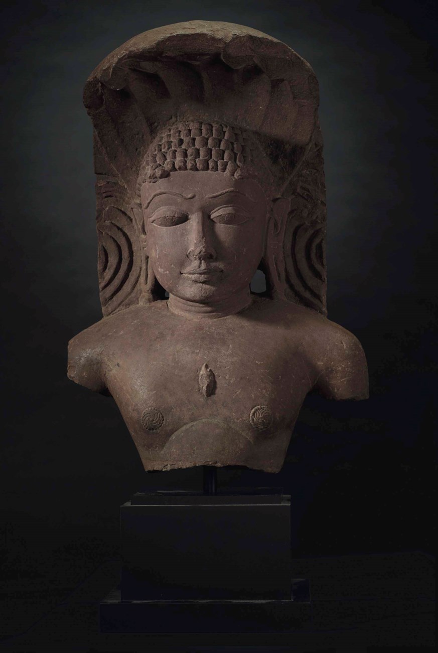 A PINK SANDSTONE BUST OF JINA PARSHVANATHA