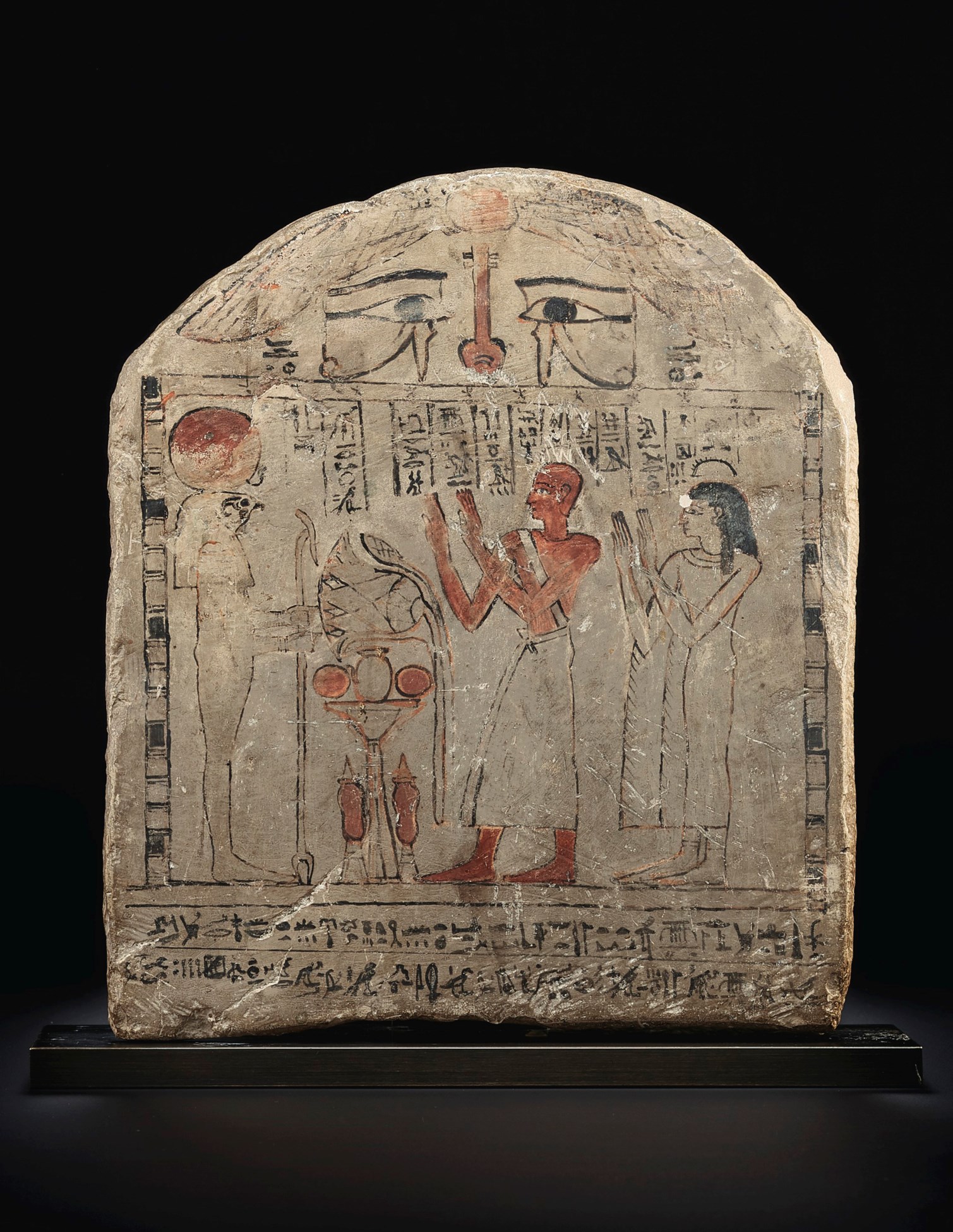 AN EGYPTIAN PAINTED LIMESTONE ROUND-TOP STELE FOR NES-PA-KA-SHUTY AND ...
