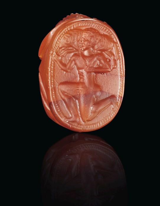 A GREEK CARNELIAN SCARAB WITH A YOUTH SHOULDERING A RAM
