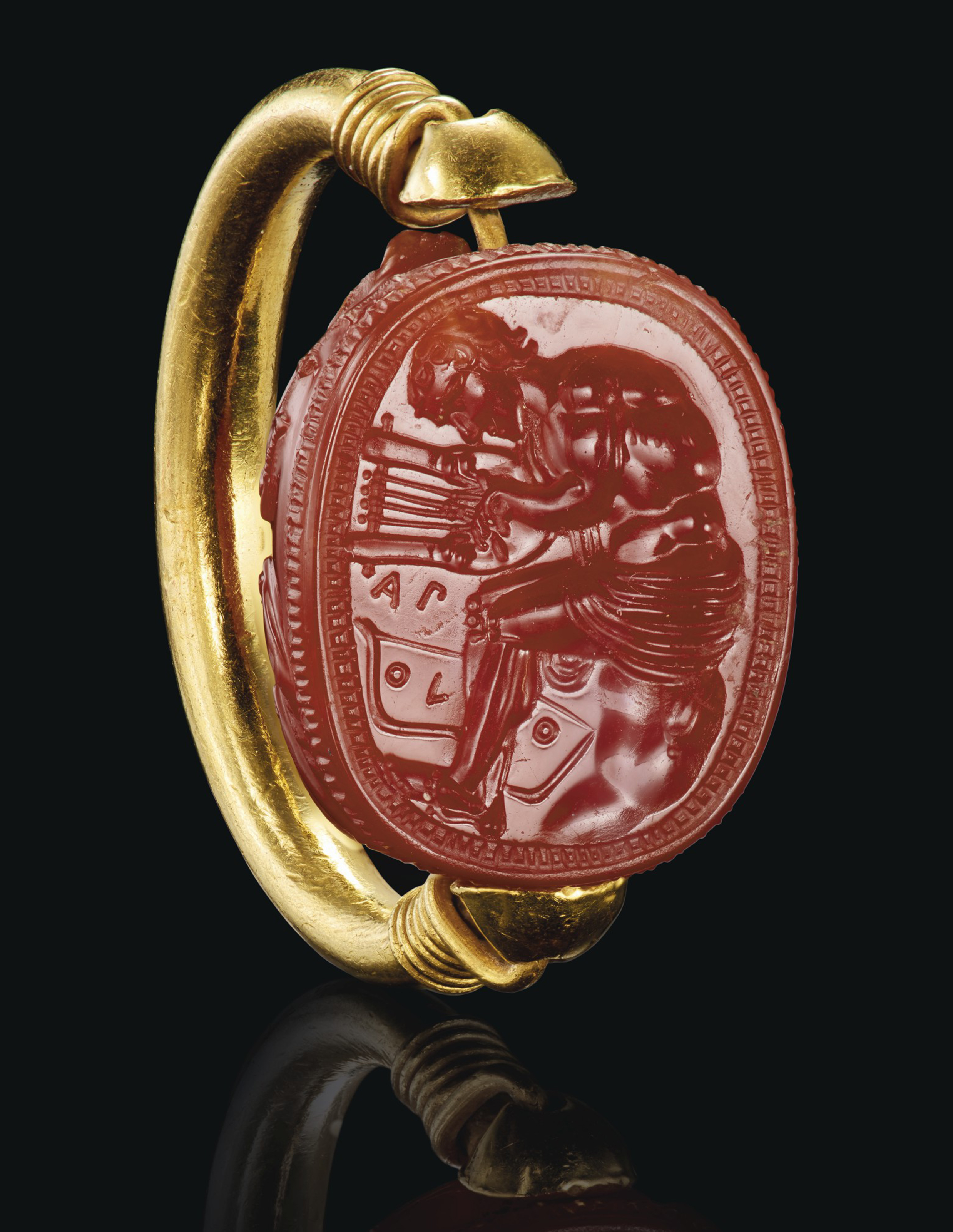 AN ETRUSCAN GOLD AND CARNELIAN SCARAB FINGER RING WITH APLU