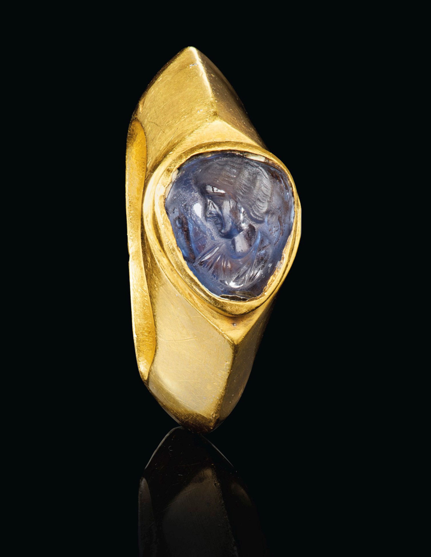 A LATE ROMAN GOLD AND SAPPHIRE FINGER RING WITH A PORTRAIT BUST OF AN ...