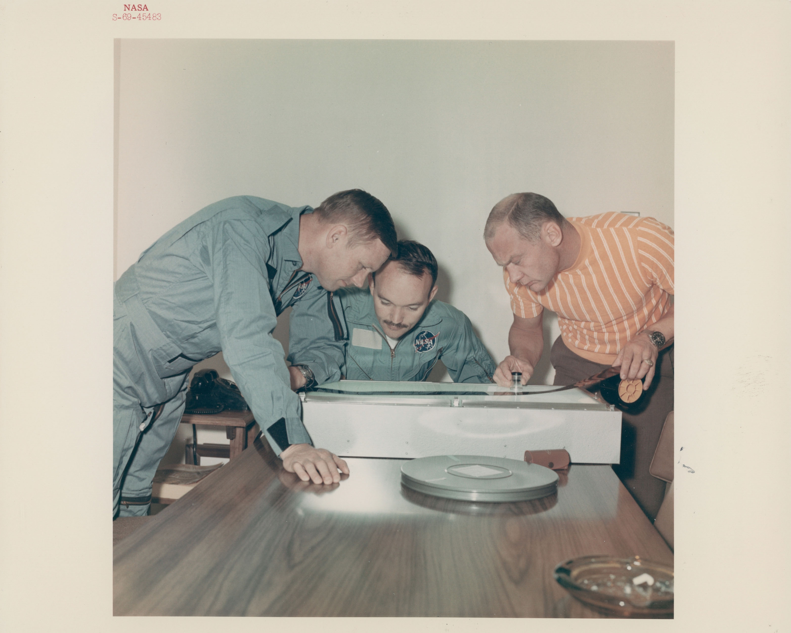 The crew examining the photographic film; NASA officials receiving ...