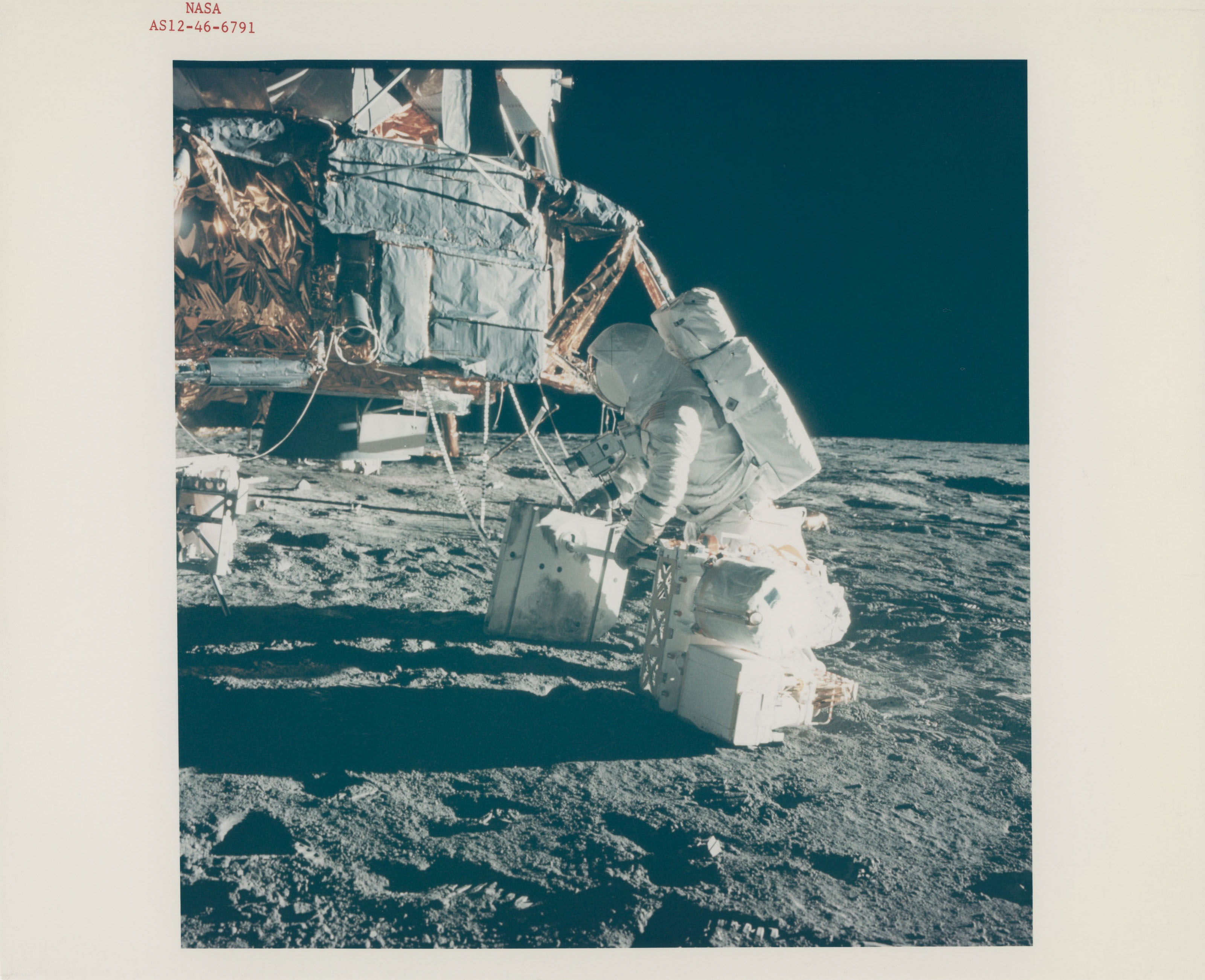 Views of Alan Bean preparing to carry the scientific equipment; Bean ...