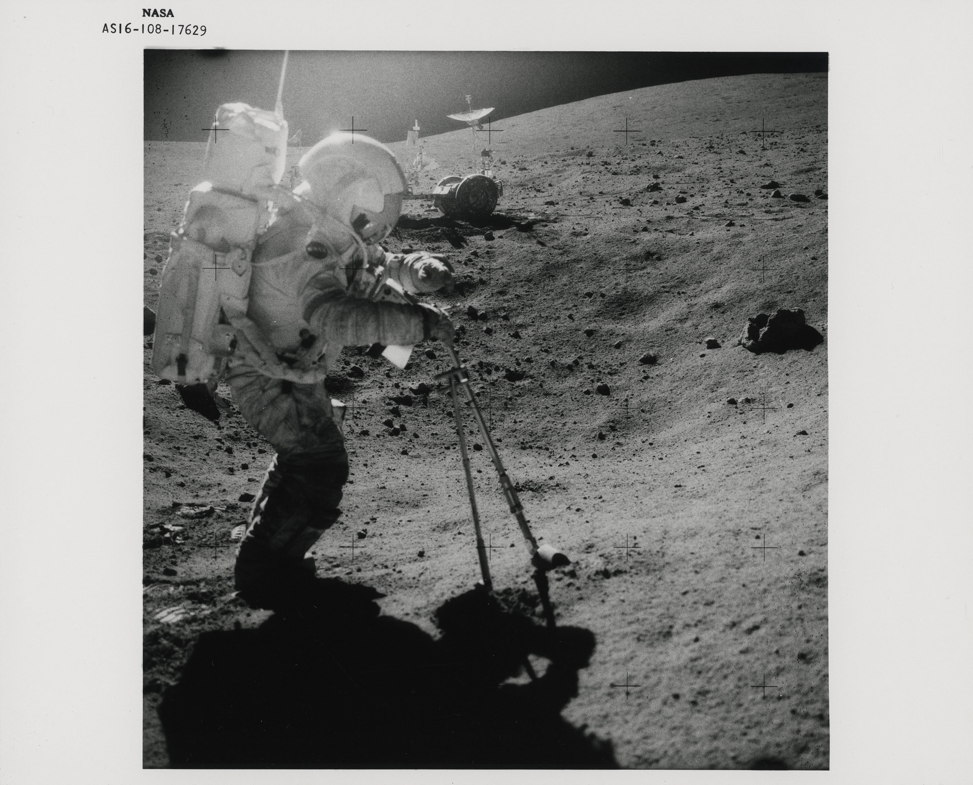 John Young collecting lunar soil; Young at the back of the Rover ...