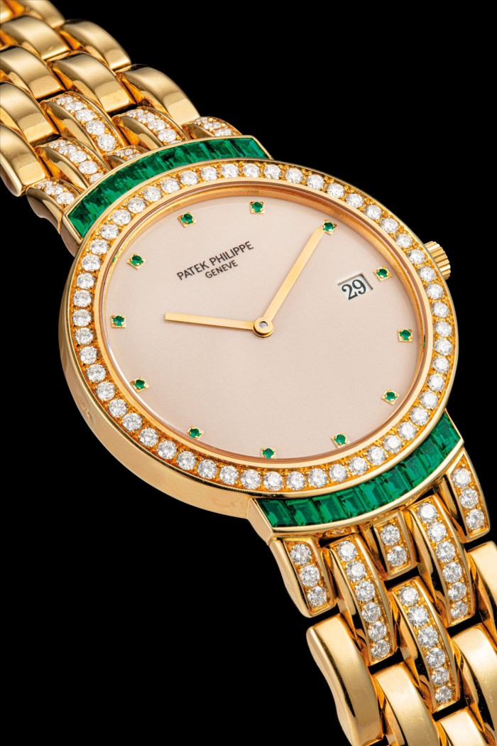 PATEK PHILIPPE. AN 18K GOLD, DIAMOND AND EMERALD-SET BRACELET WATCH ...