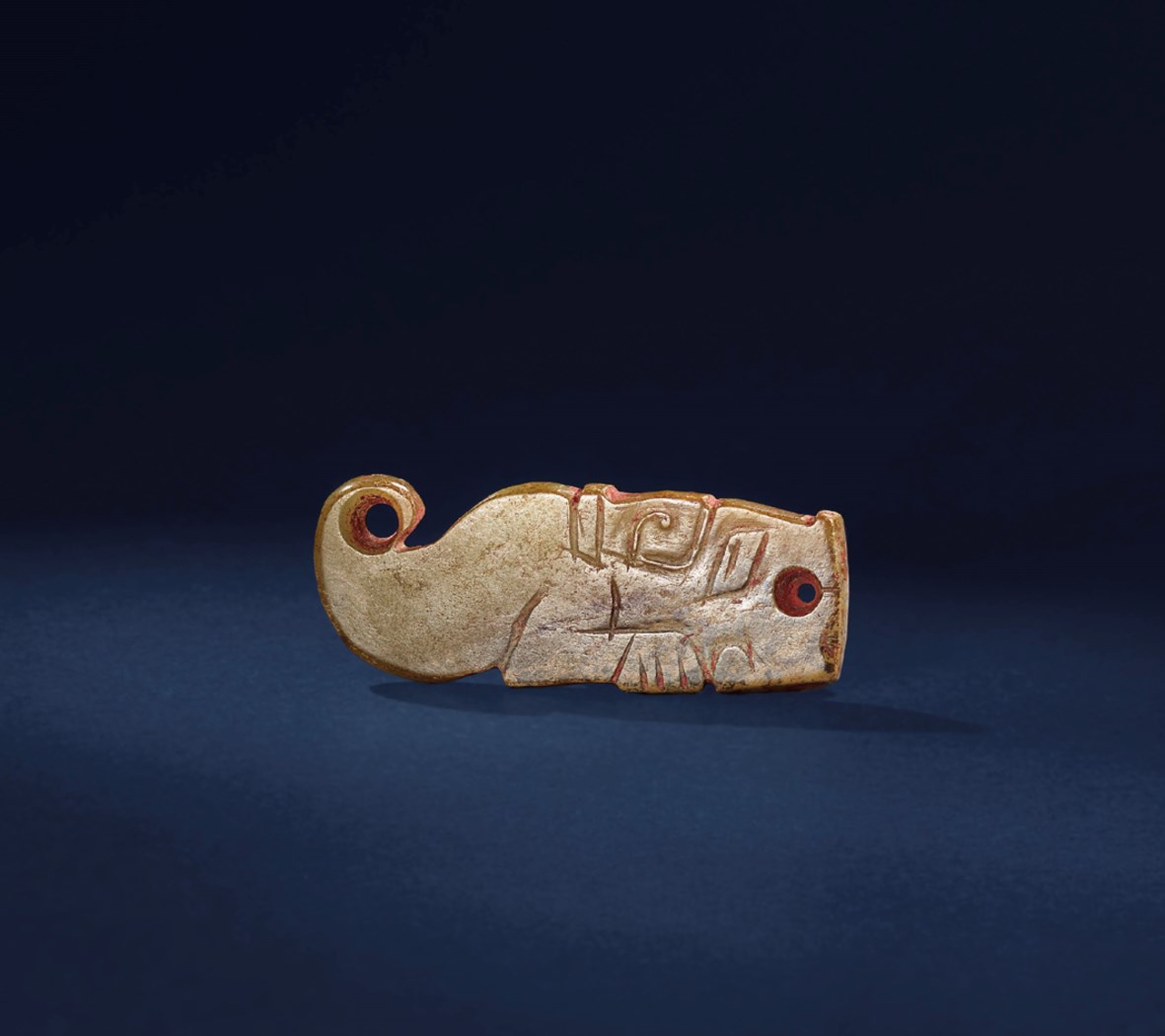 A PALE GREENISH-YELLOW AND RUSSET TIGER-FORM PENDANT, LATE SHANG-EARLY ...