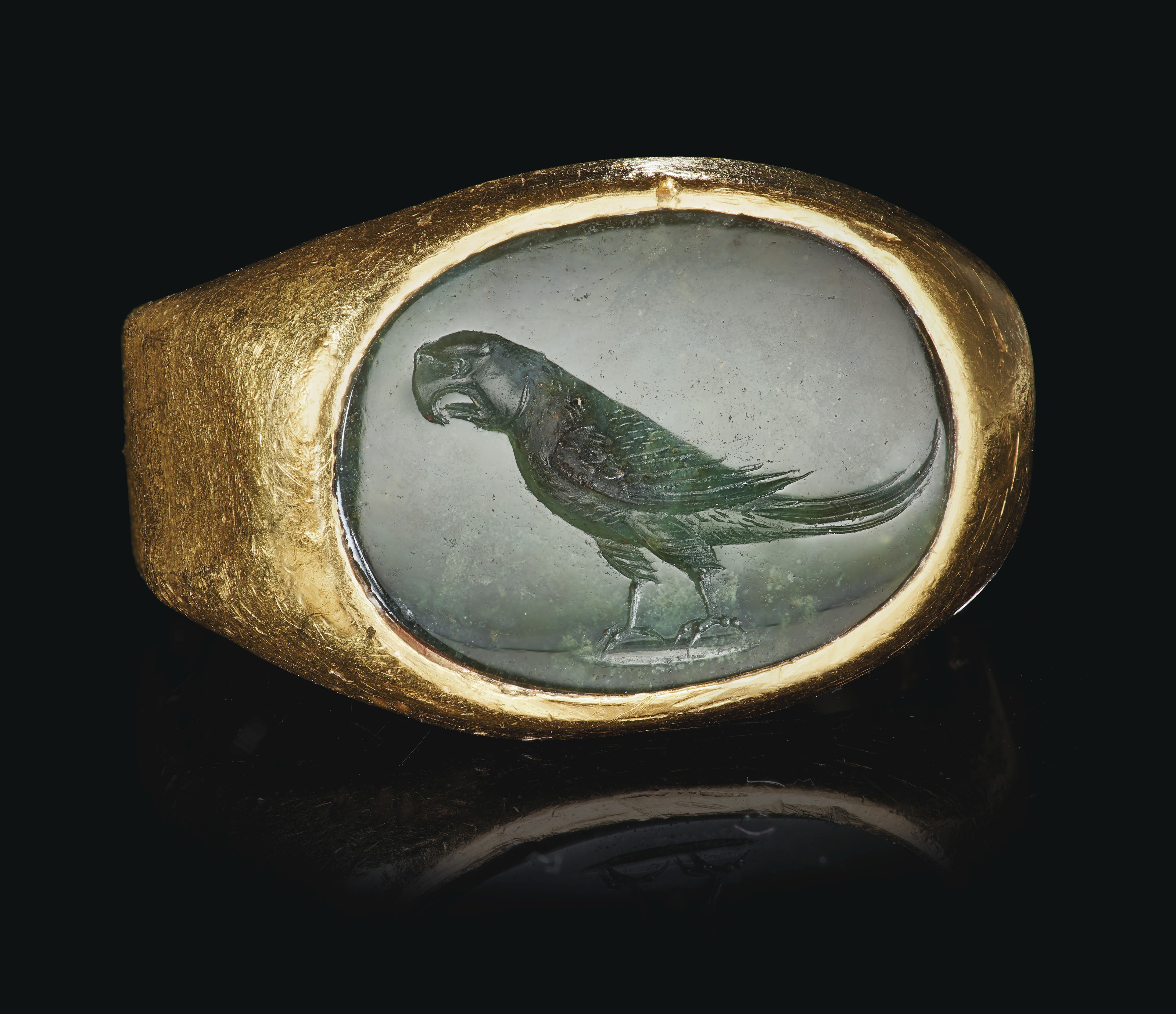 A ROMAN GOLD AND GREEN CHALCEDONY FINGER RING WITH A PARROT, CIRCA 1ST ...