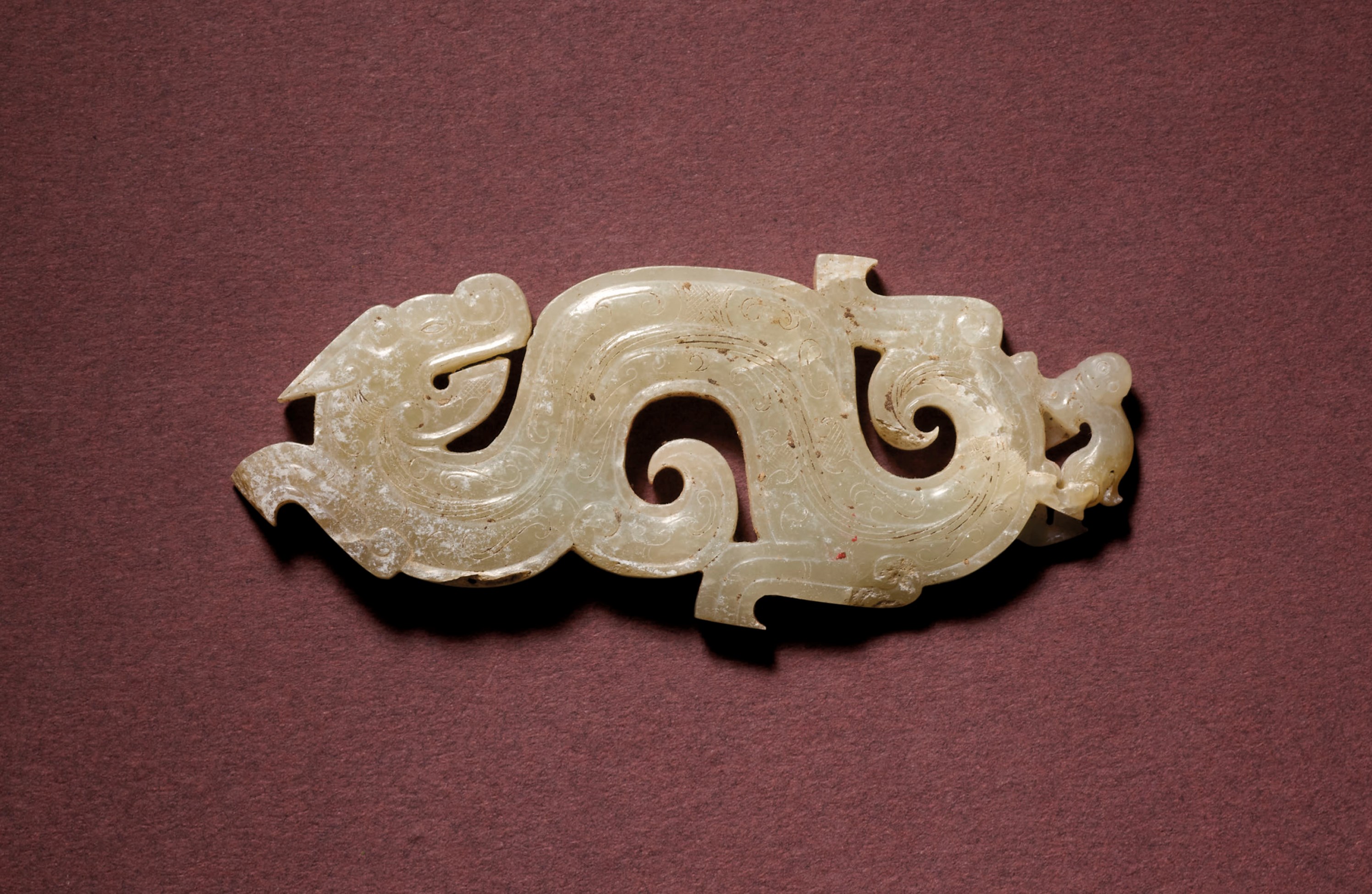 A RARE JADE RETICULATED ‘DRAGON AND MONKEY’ PENDANT, MID-WARRING STATES ...