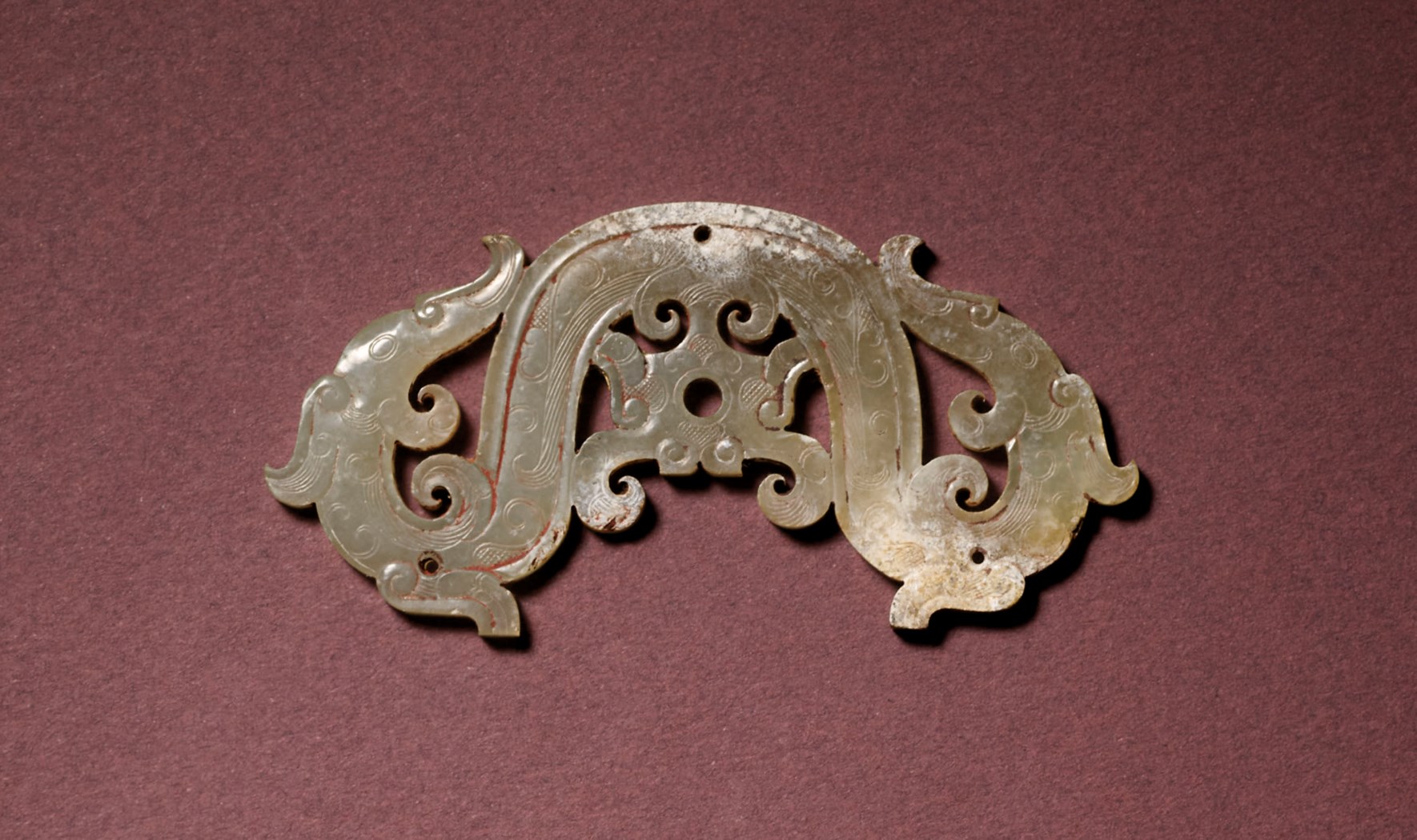 A FINELY CARVED JADE RETICULATED 'DOUBLE-DRAGON' PENDANT, MID-WARRING ...