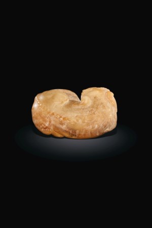 A YELLOWISH-BEIGE JADE OR HARDSTONE FIGURE OF A RECUMBENT MYTHICAL BEAST