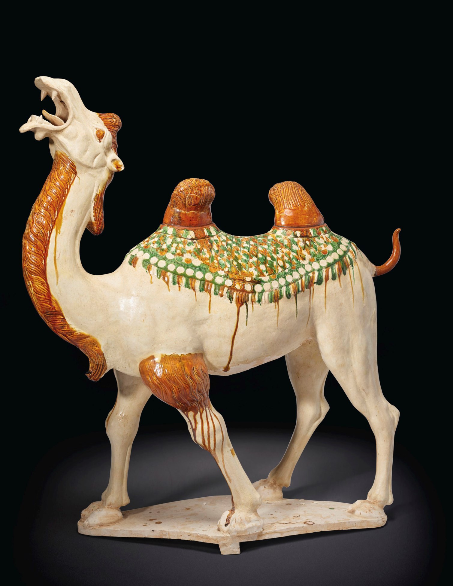 A MASSIVE SANCAI-GLAZED POTTERY FIGURE OF A STRIDING BACTRIAN CAMEL ...