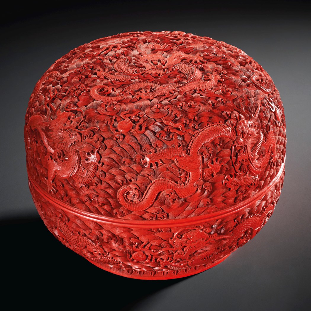 A CARVED RED LACQUER 'NINE DRAGONS' BOX AND COVER, QIANLONG PERIOD ...