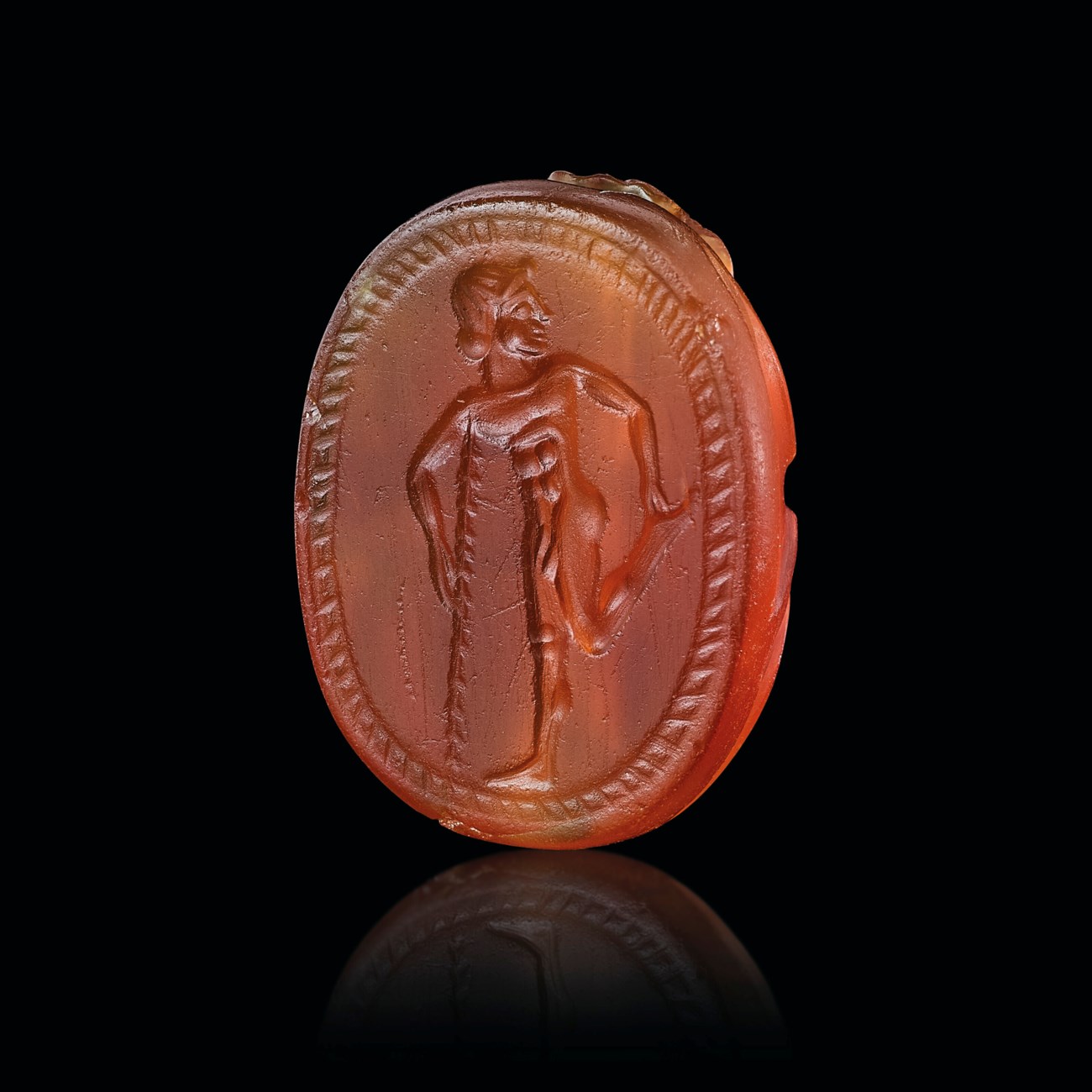 A GREEK CARNELIAN SCARAB WITH A YOUTH LEANING ON A STAFF, ARCHAIC ...